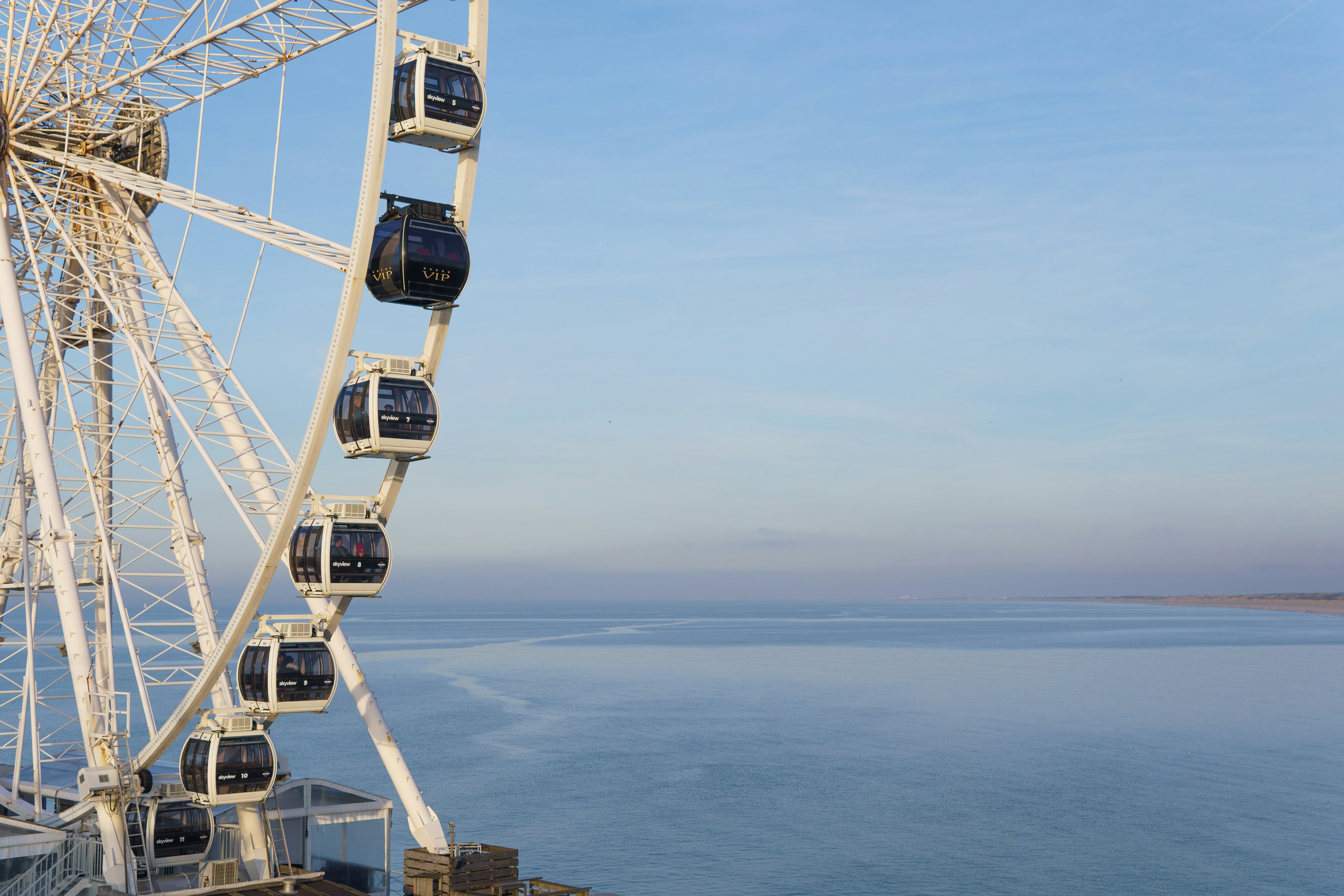 Circular Gig: A Partial Ferris Wheel Over a Serene Seascape