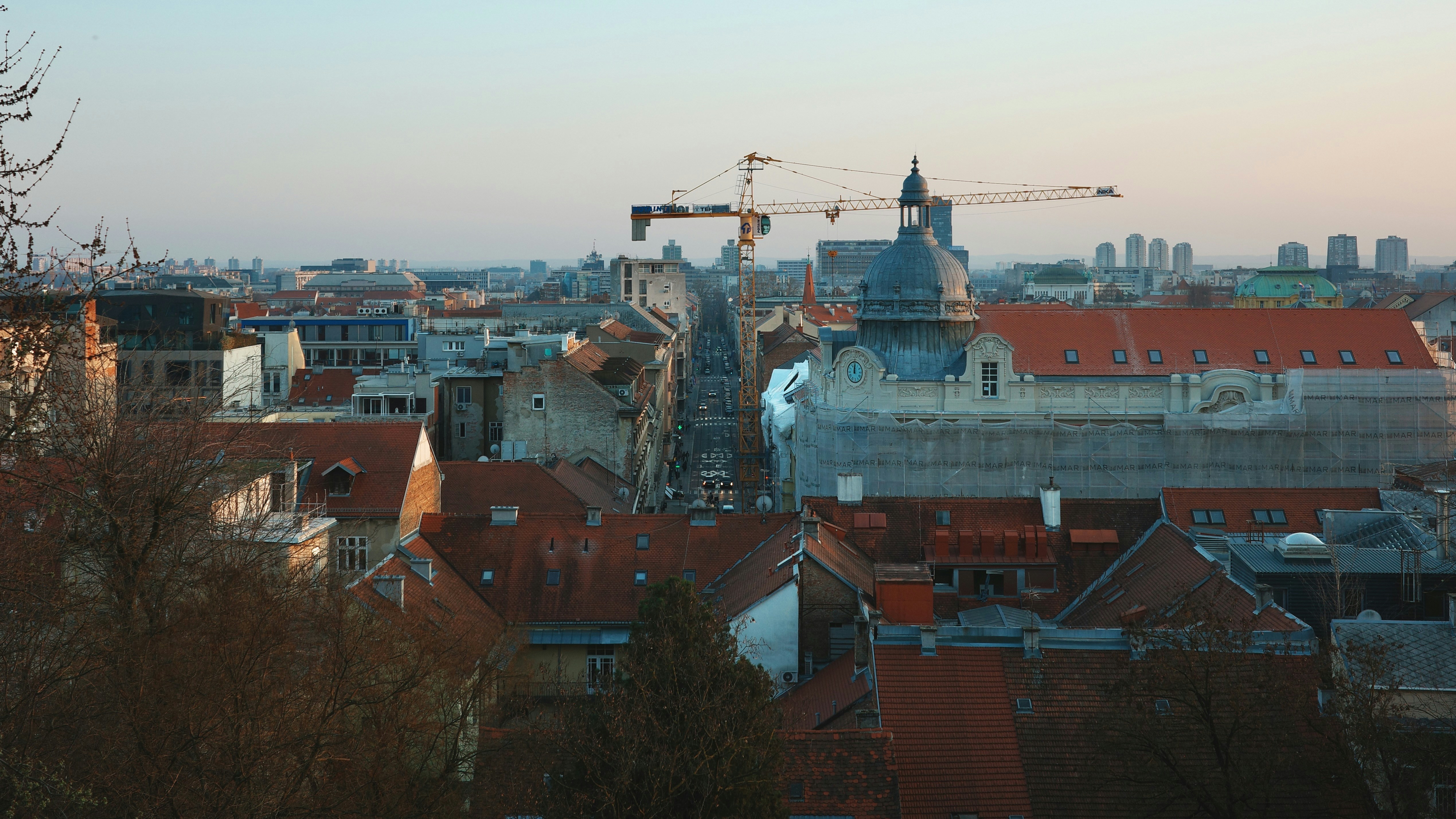 Rooftop Calm Over a City at Dusk with a Crane's Silhouette