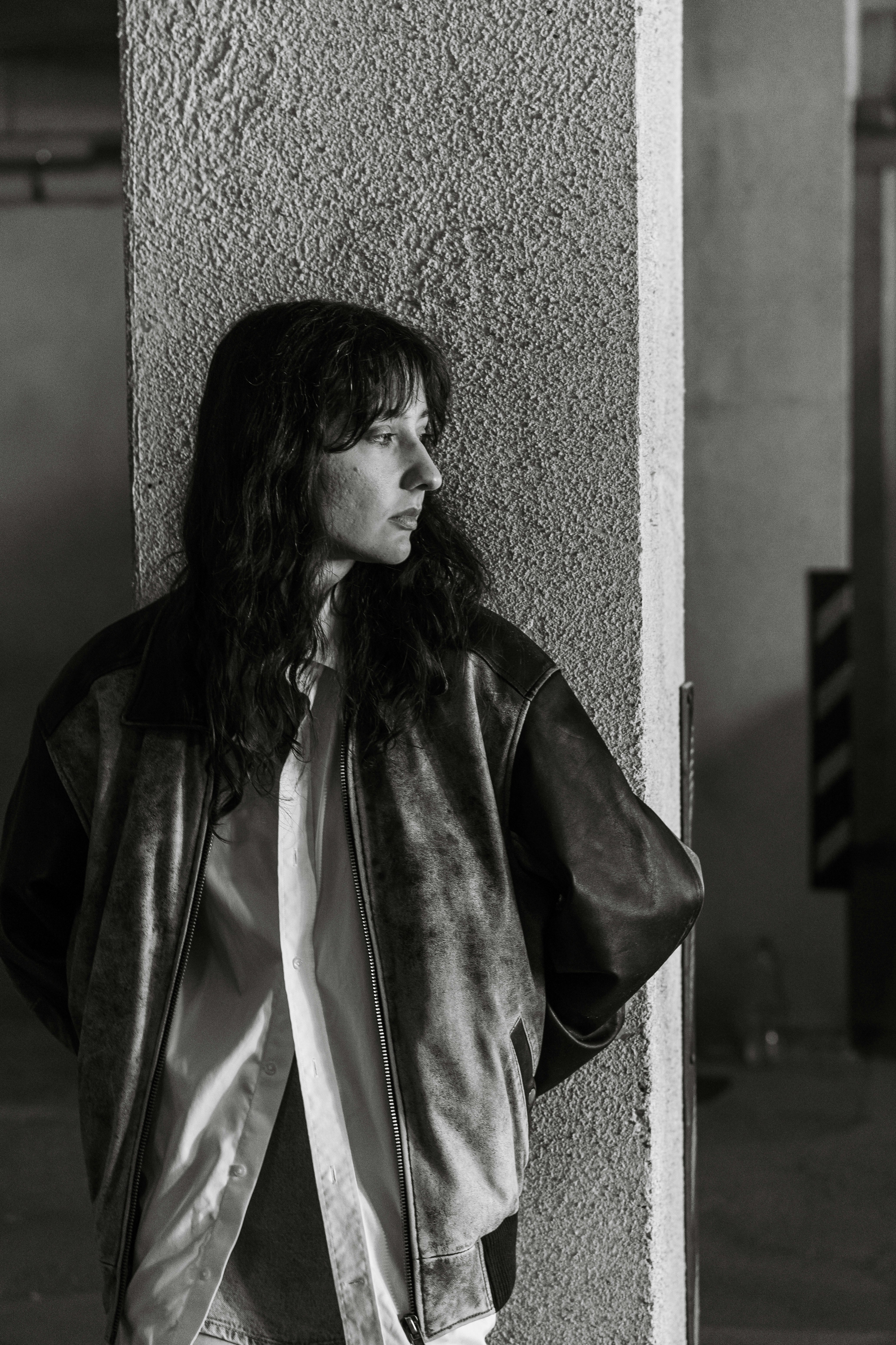 Portrait in Concrete Light: Woman in Leather by a Pillar