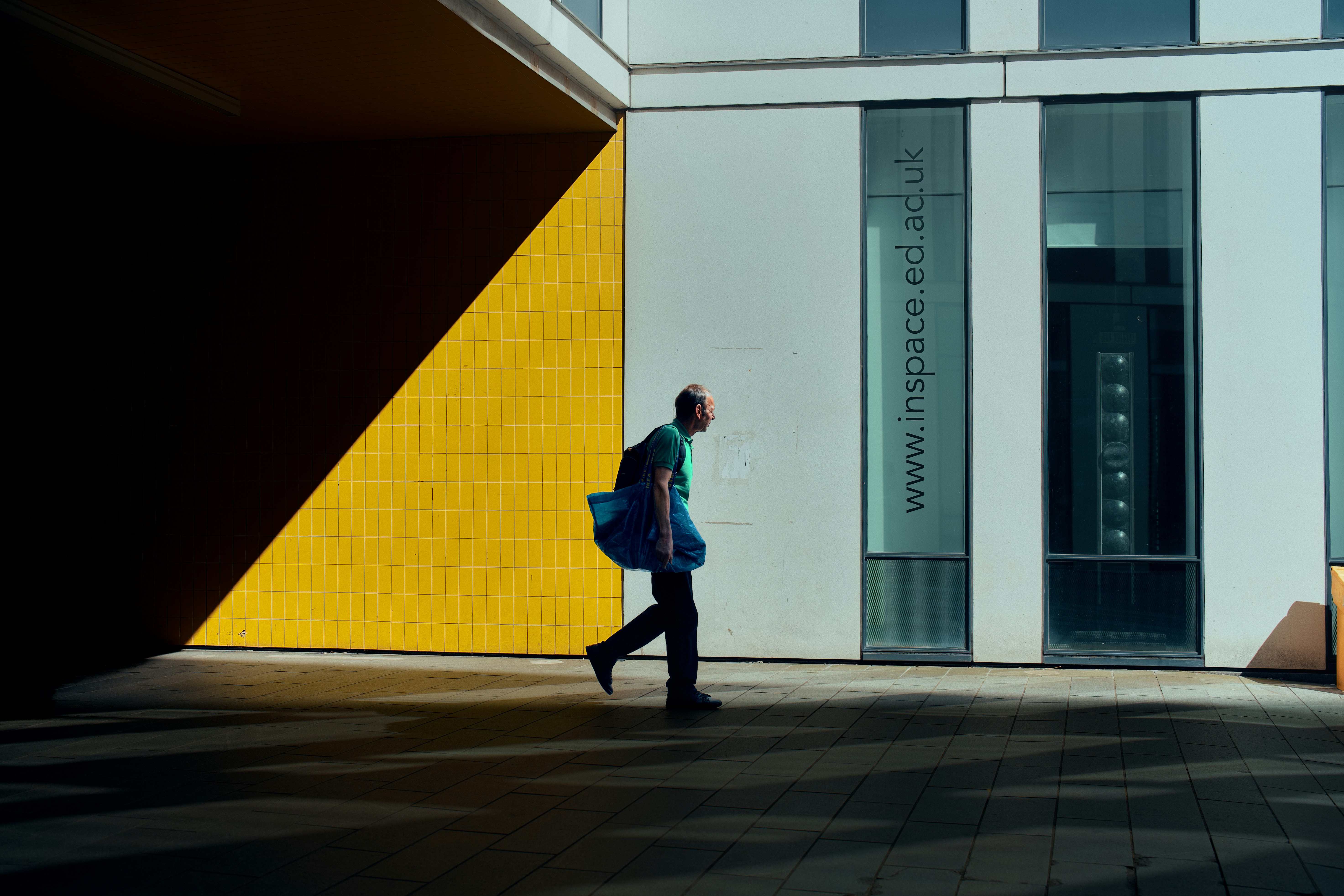 Messenger in the Shadowed Corridor: A Lone Figure Crossing the Geometric City