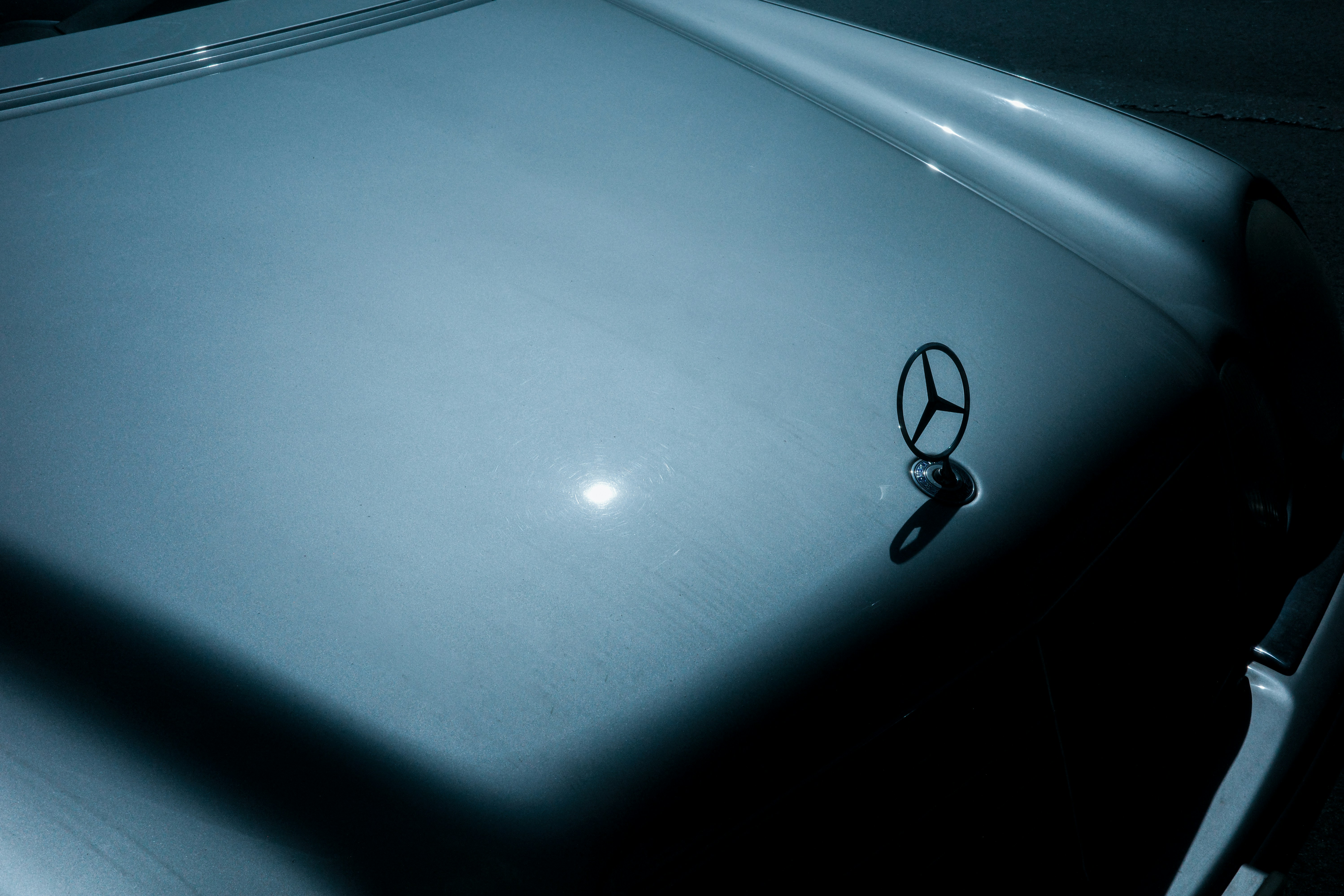 Mercedes-Benz Emblem Awash in Dusky Light on a Classic Hood
