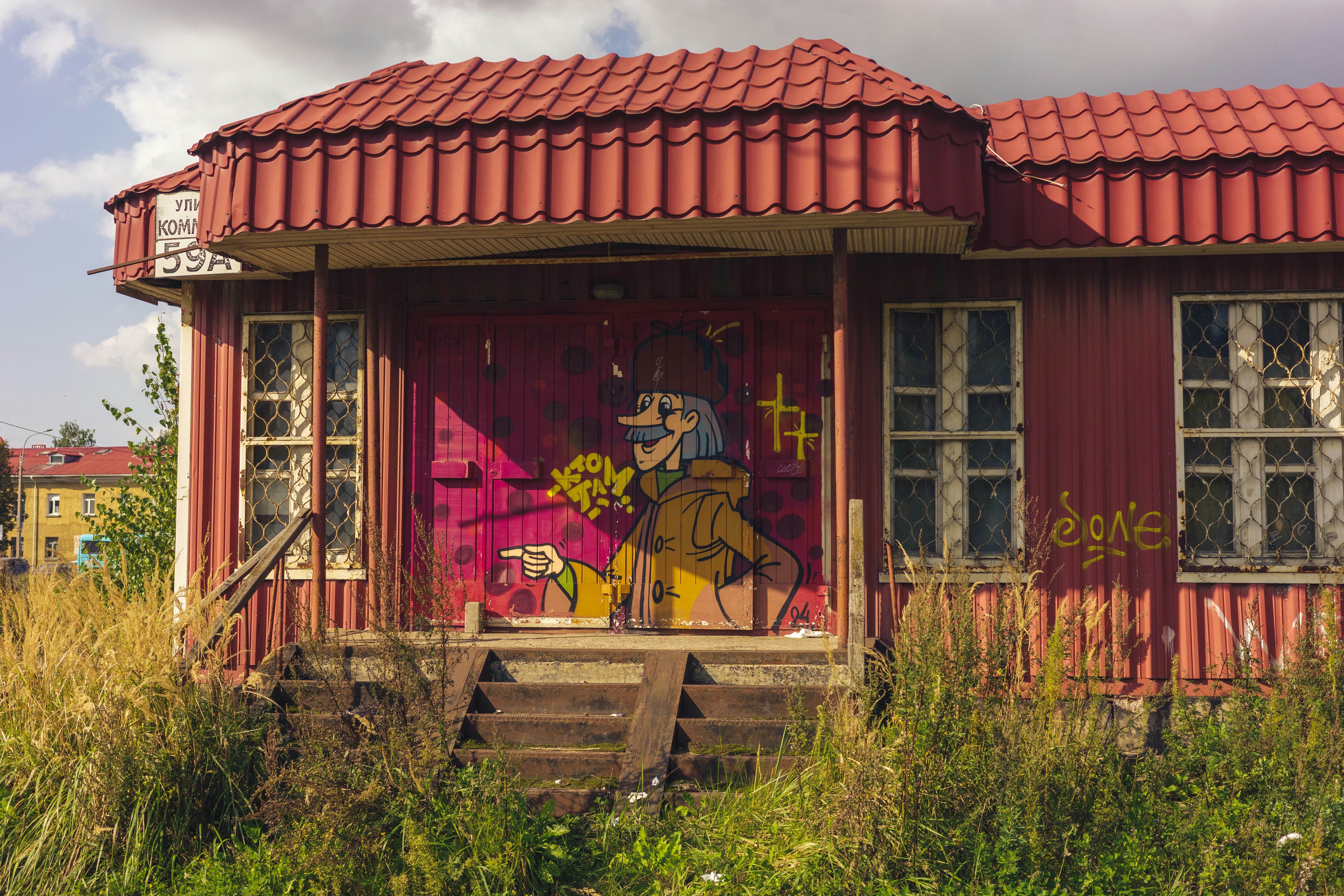 Graffiti on a Weathered Red House: A Deserted Street Art Scene