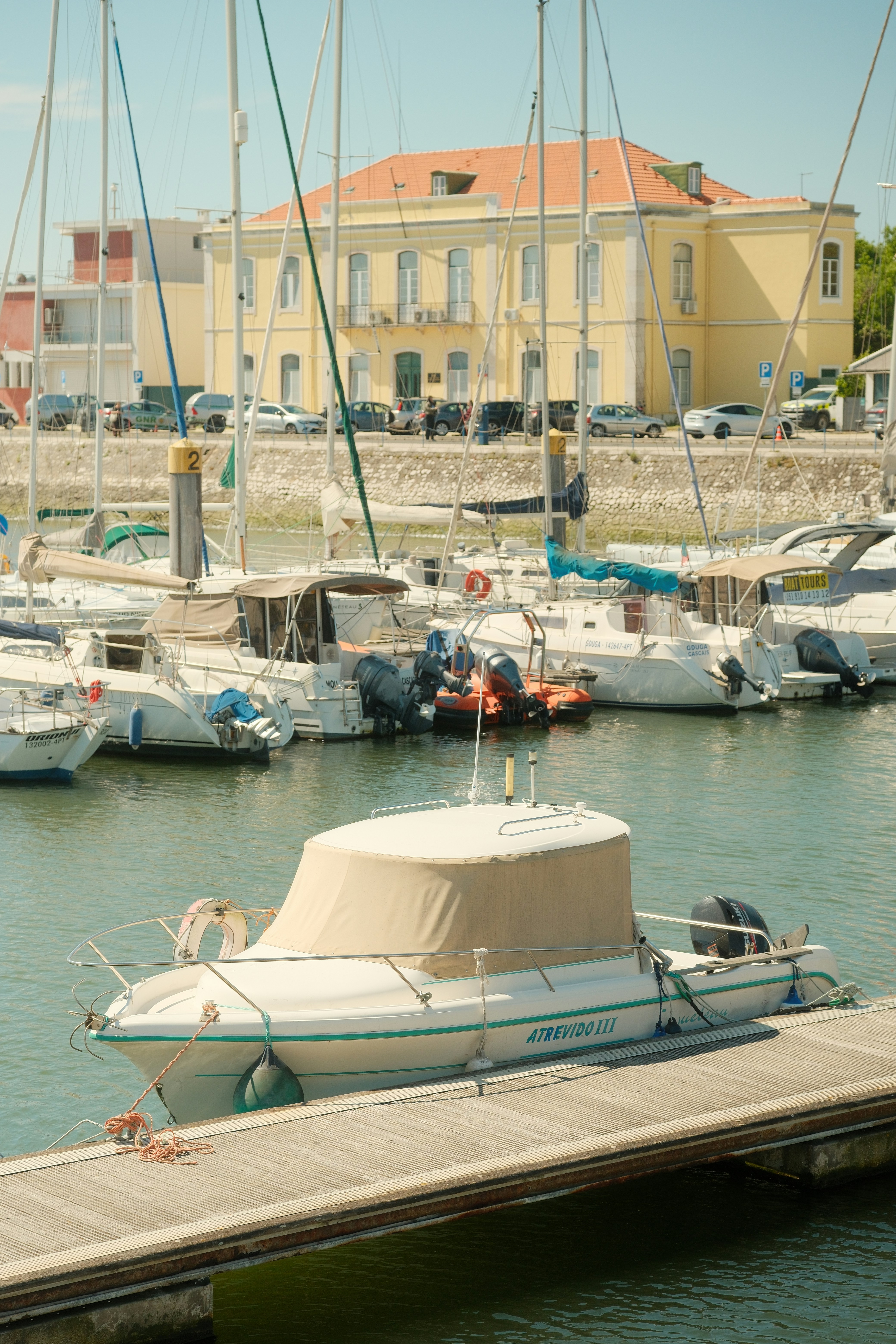 Harborfront in Soft Light: Boats, Sails, and a Quiet Street