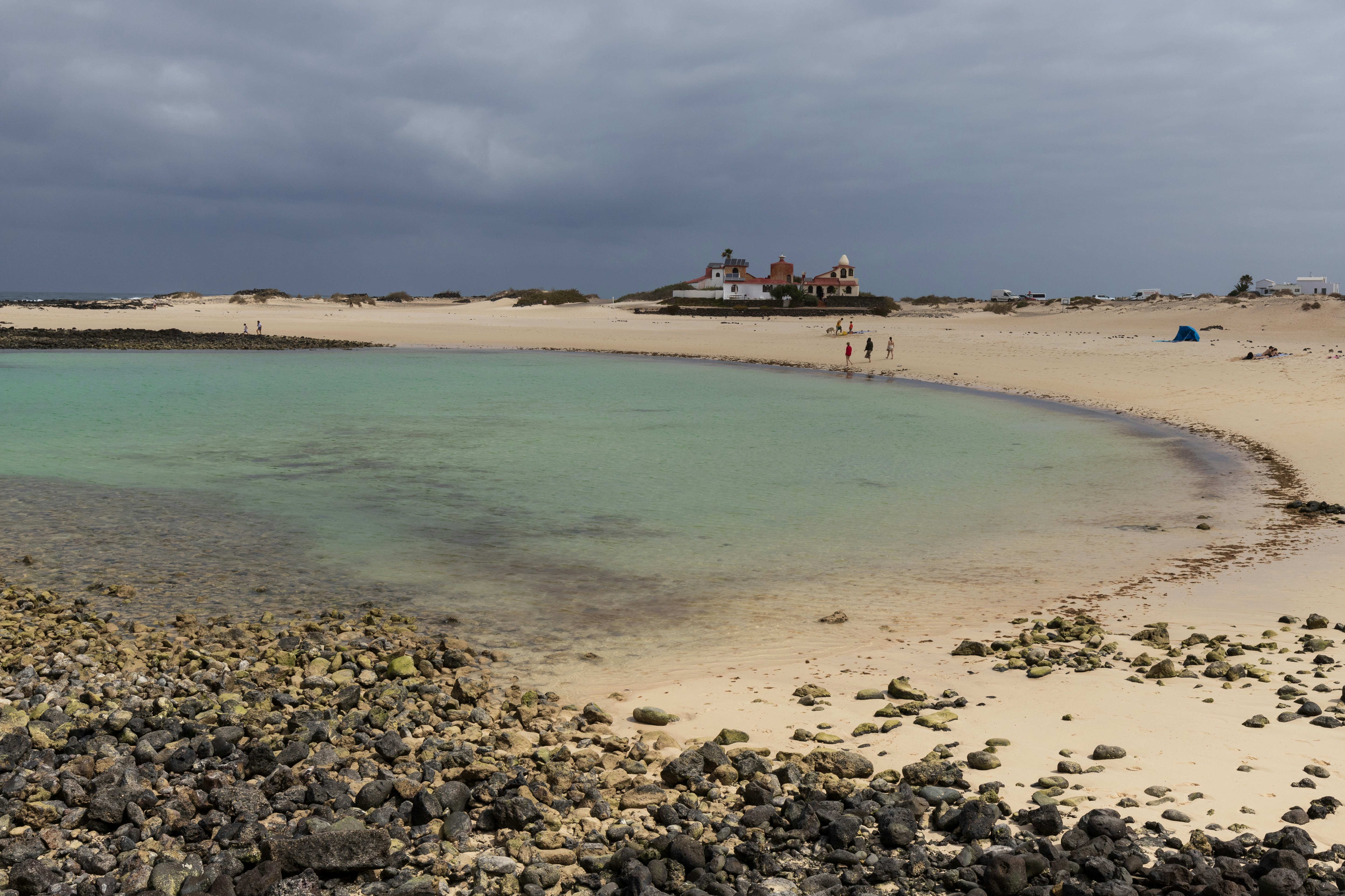 Village on the Dune-Curve: A Quiet Lagoon Under Storm-Bleached Sky