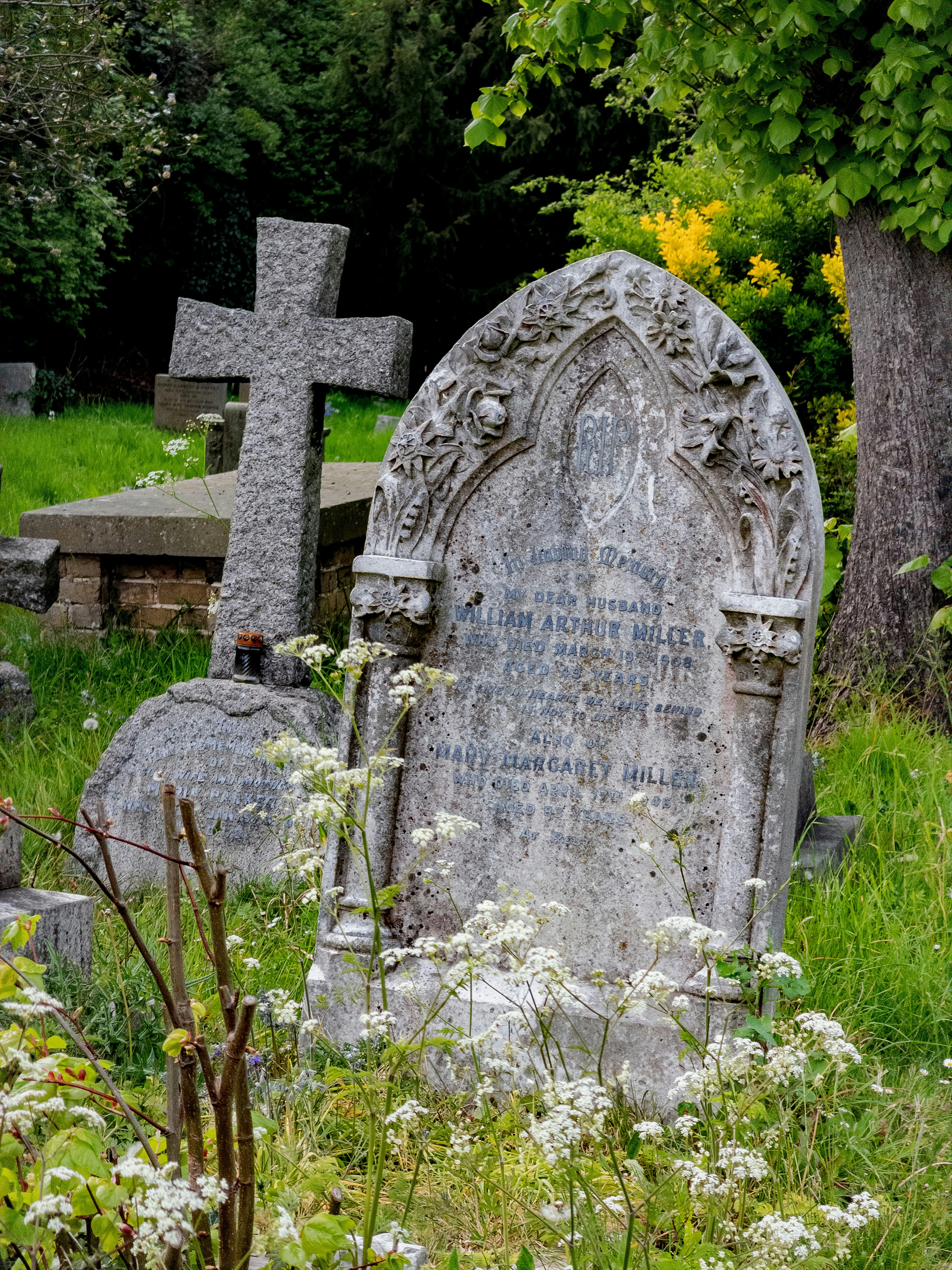 Weathered Gothic Gravestone Amid Wildflowers