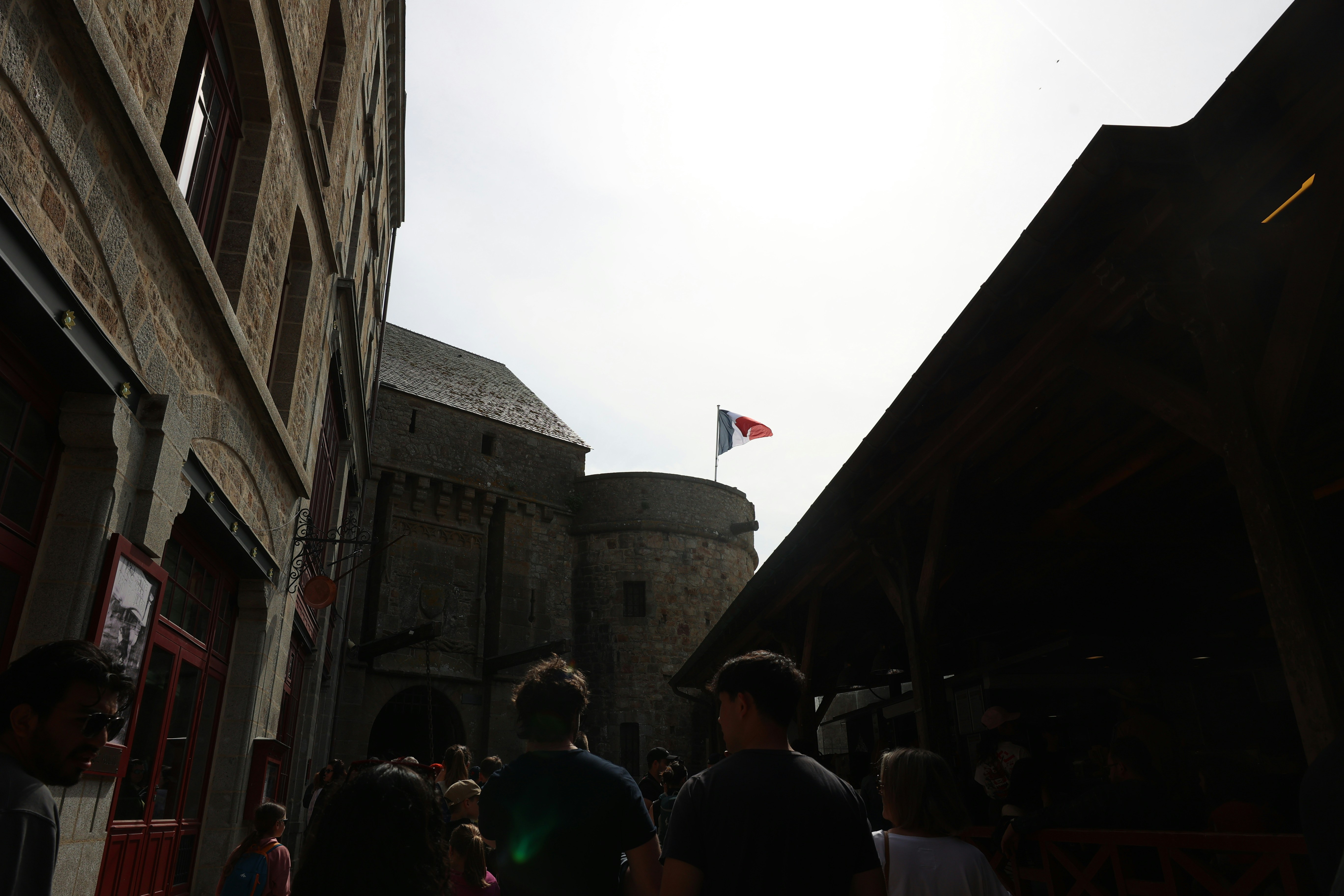Courtyard Confluence: People Gather Under a Medieval Fortified Landmark
