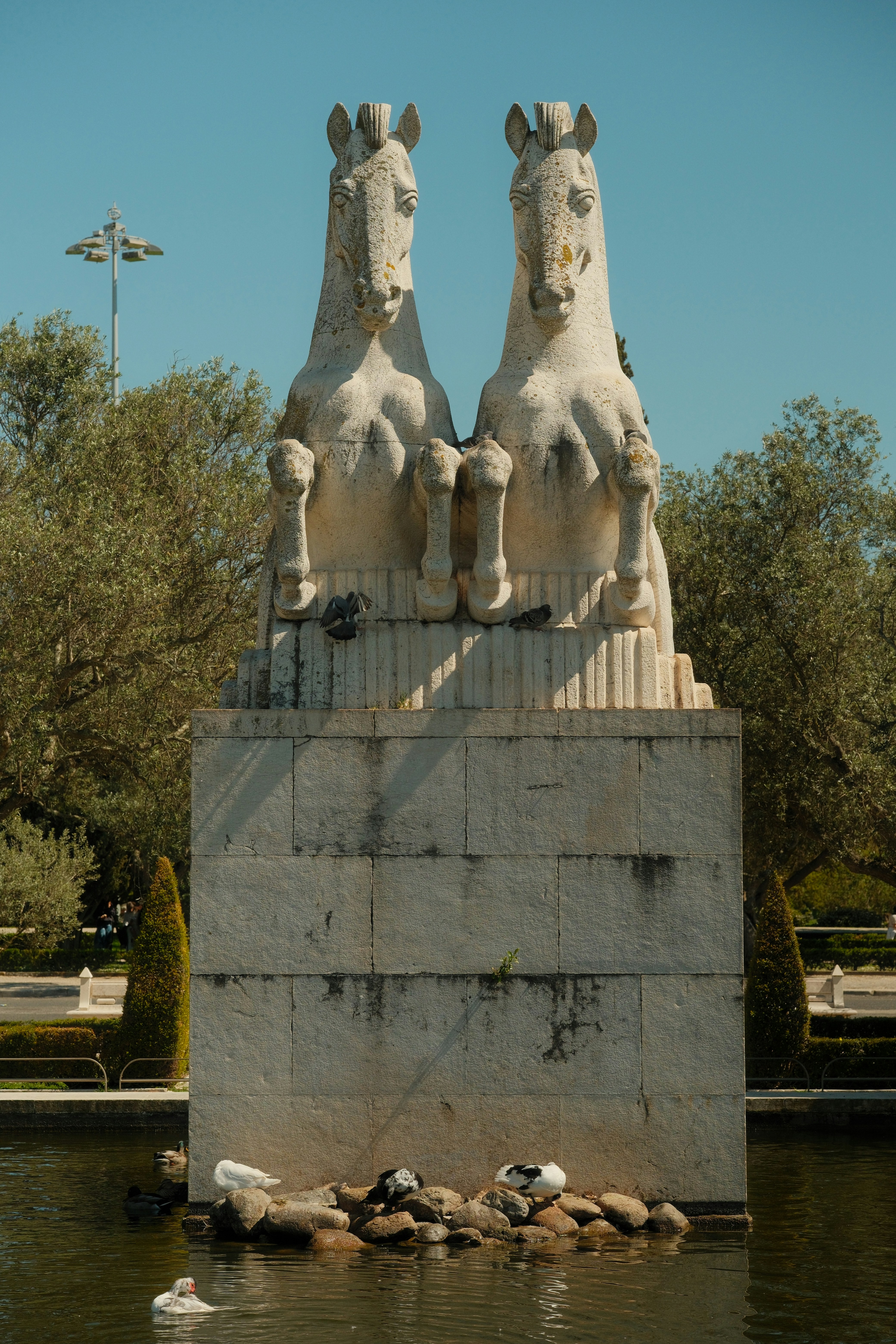 Twin Granite Horses Guarding a Tranquil Reflective Basin