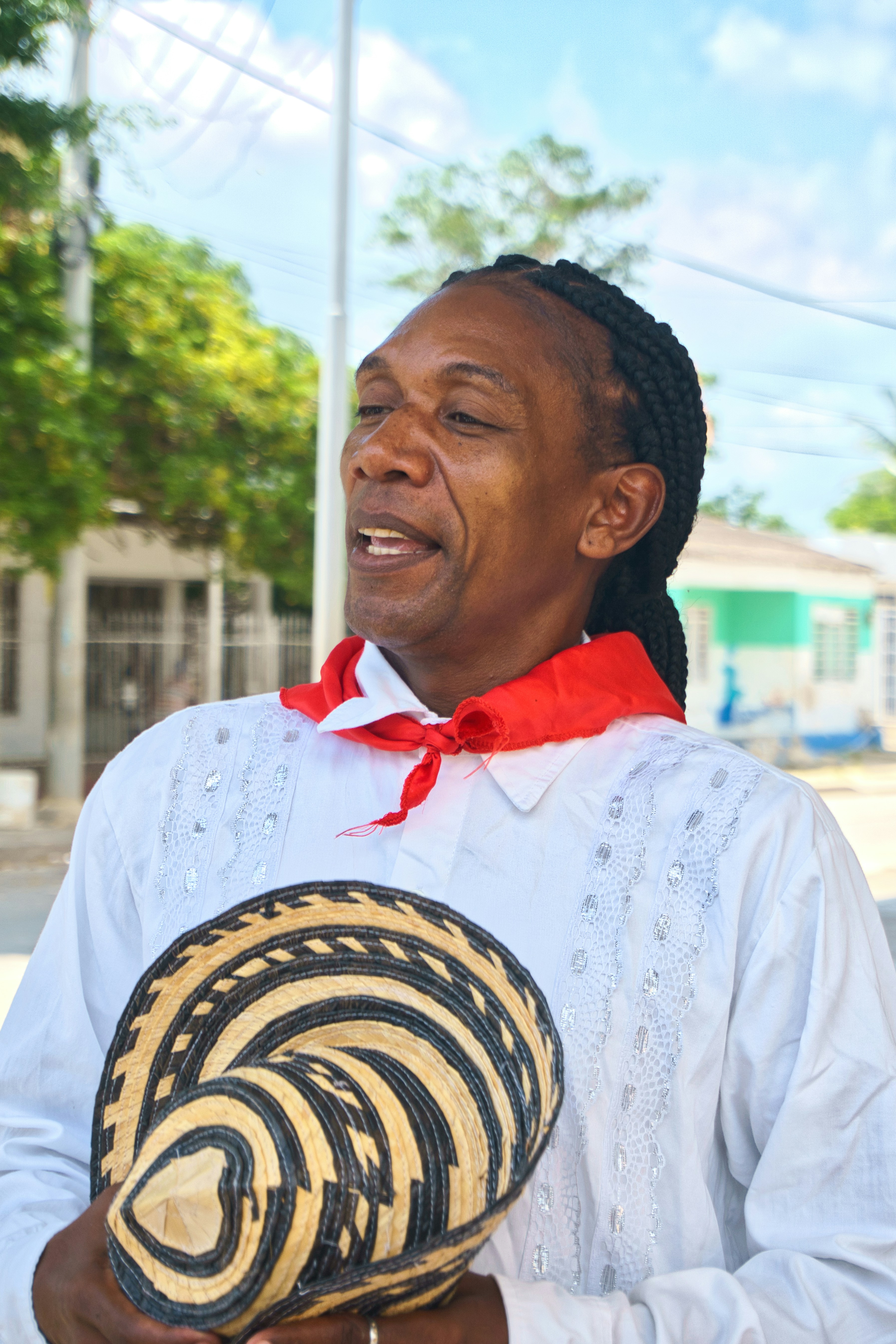 Portrait of a joyful street performer with a woven straw hat