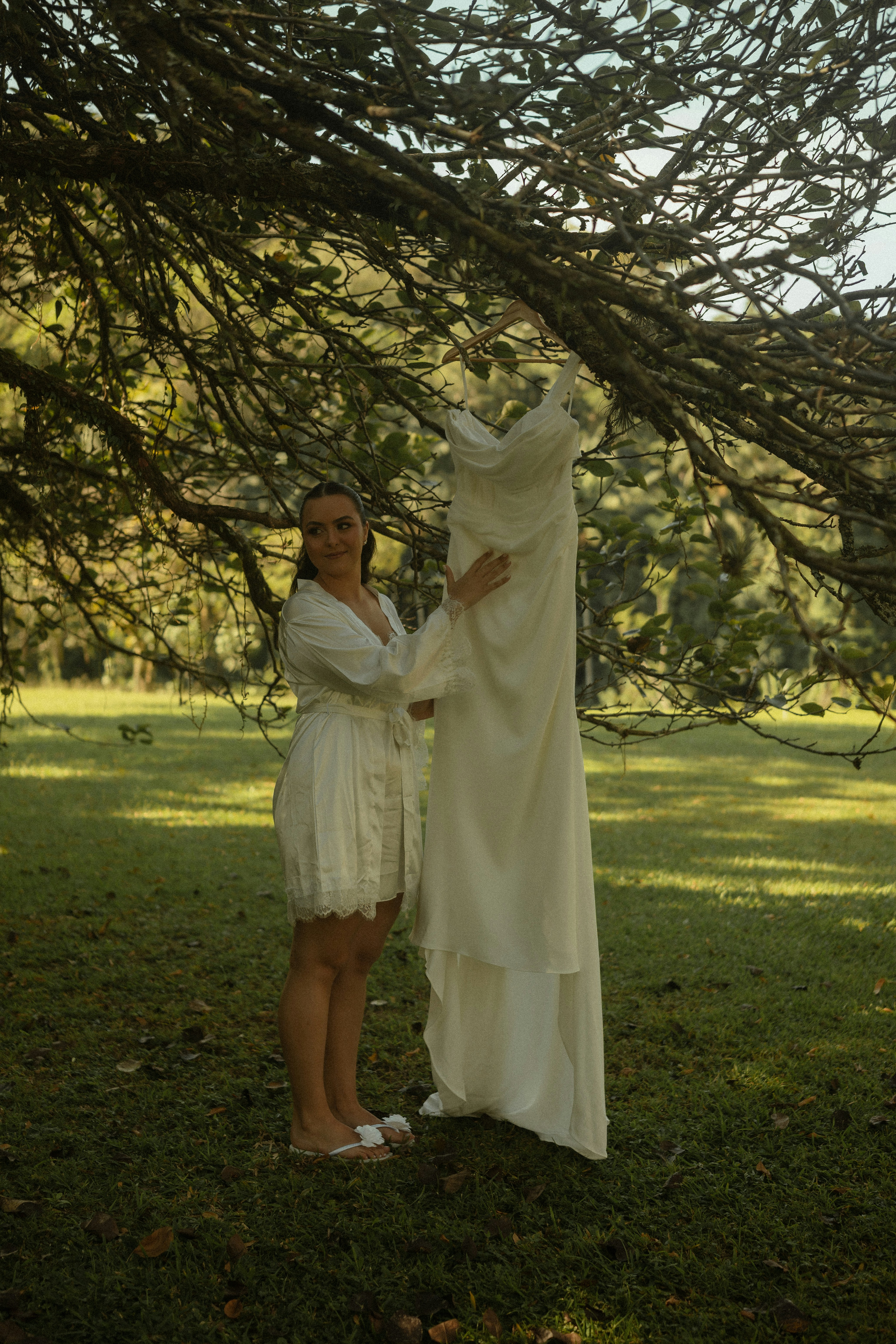 Bride in White Beneath Branches: A Gentle Moment of Lend and Lift