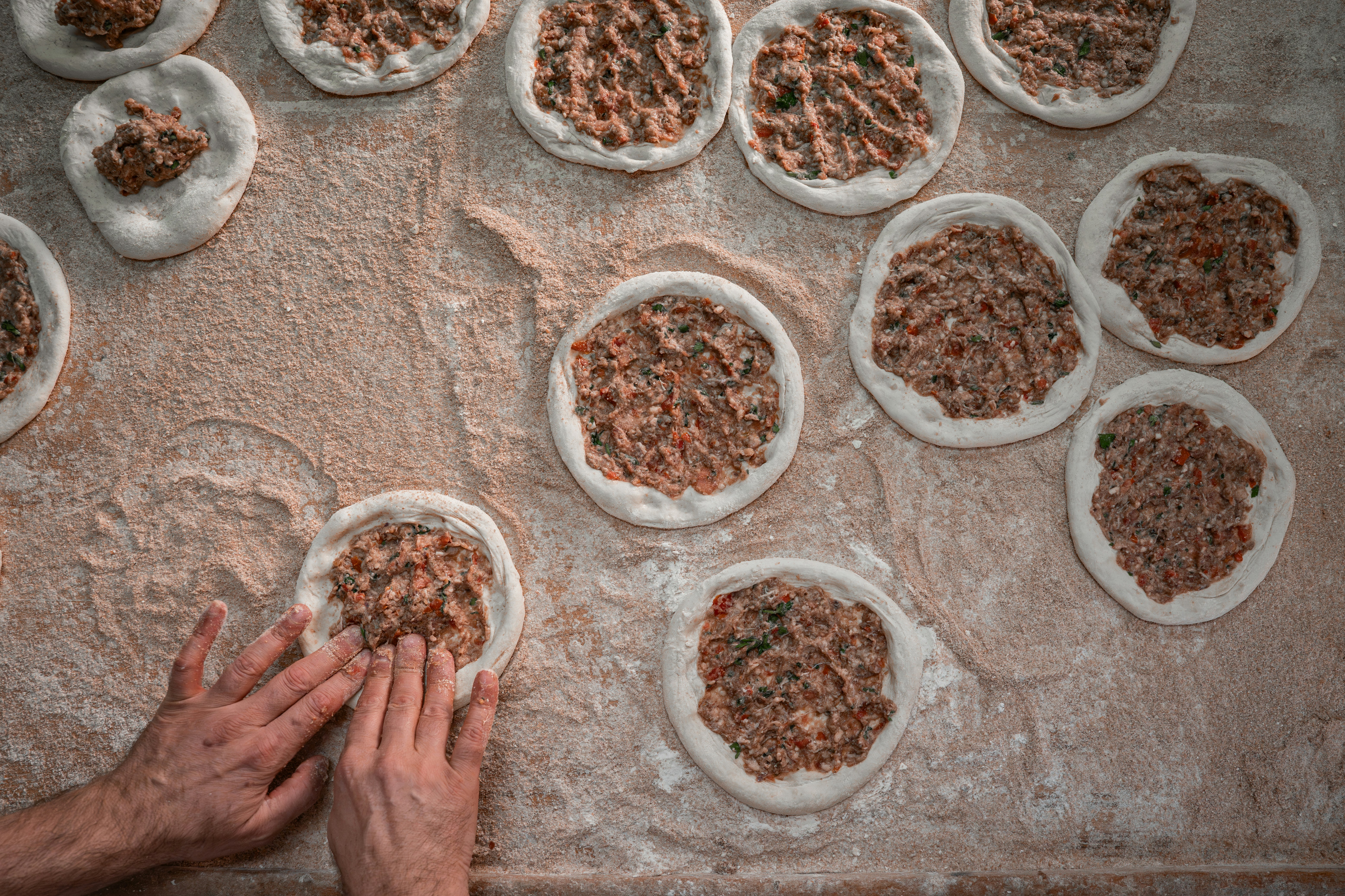 Hand-forming Mince Pastries on a Floured Tray