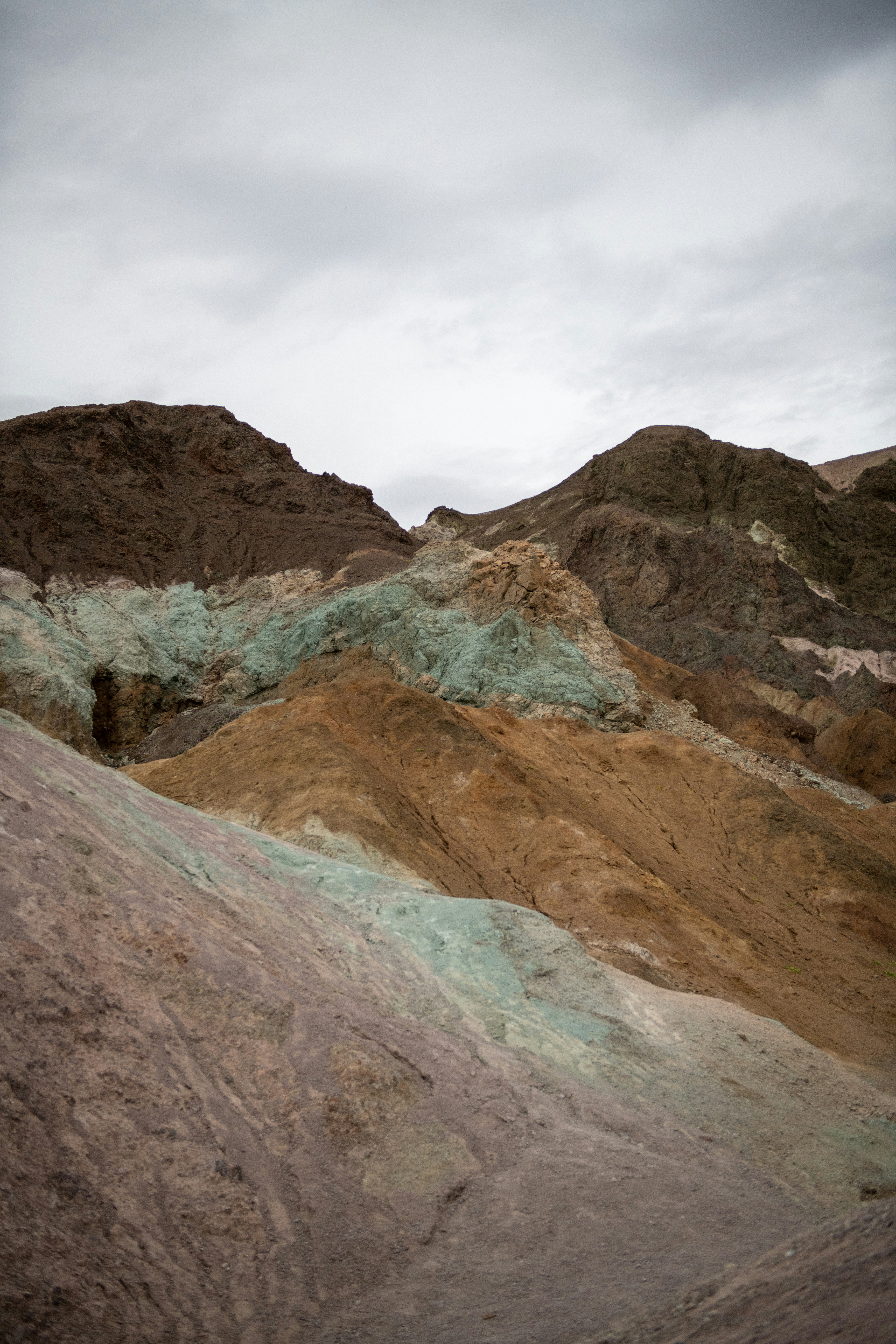 Color-Washed Badlands Under Clouded Sky