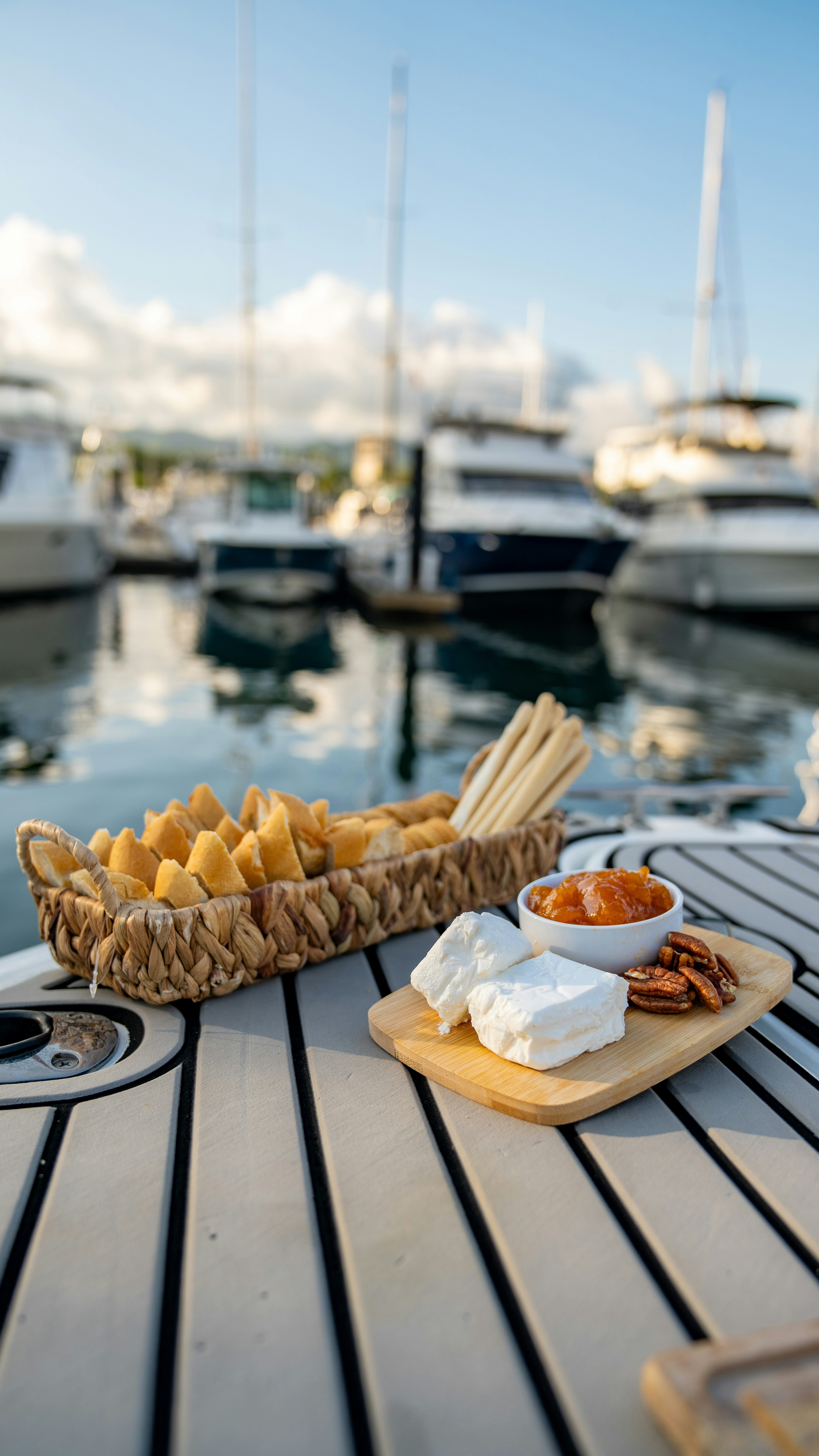 Casual spread by the marina: cheese, bread, and apricot dip near moored boats