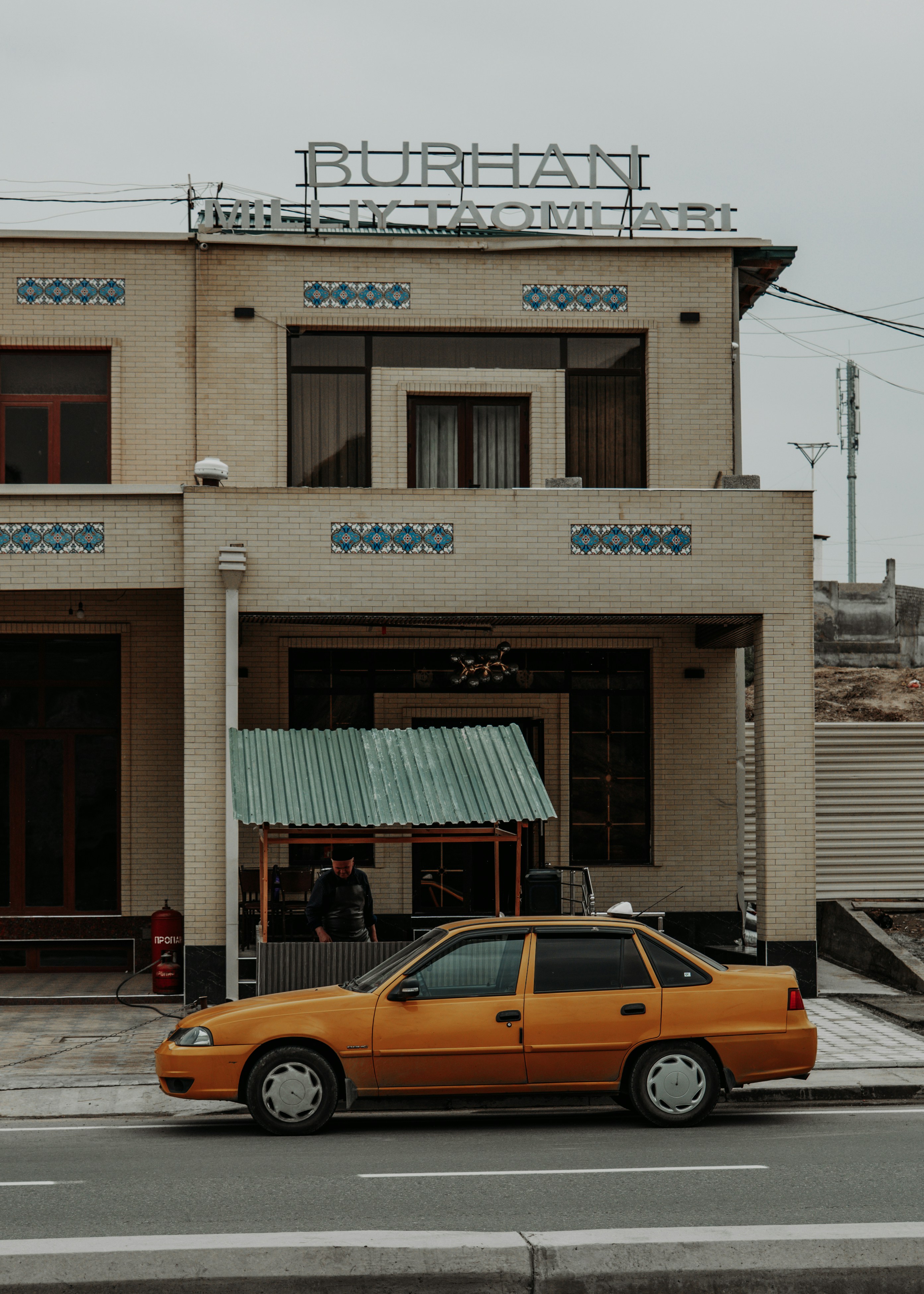 Yellow Taxi in Front of a Retro-Style Art Building