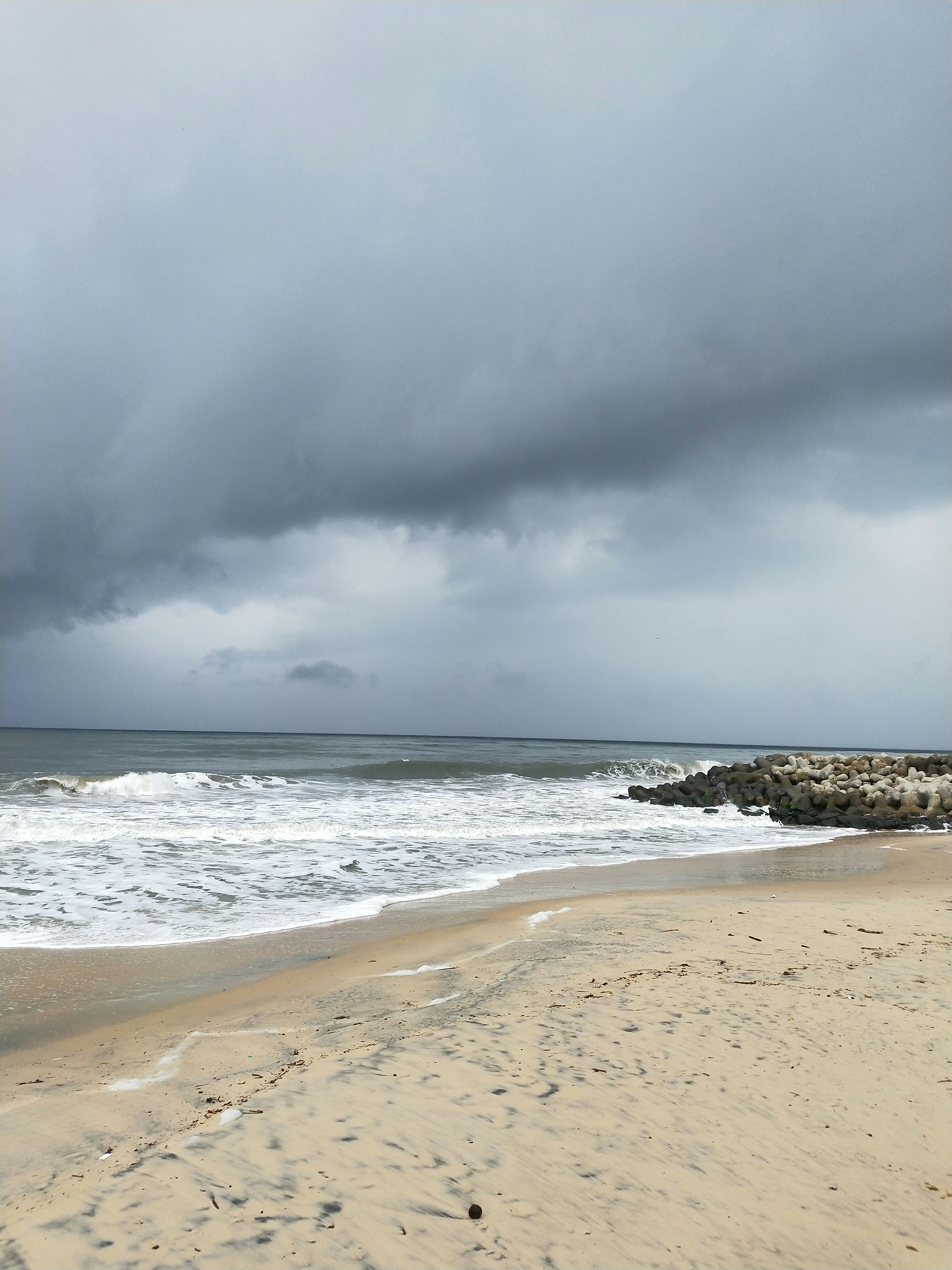 Storm-Brokered Shoreline: A Quiet Beach underlooming Clouds