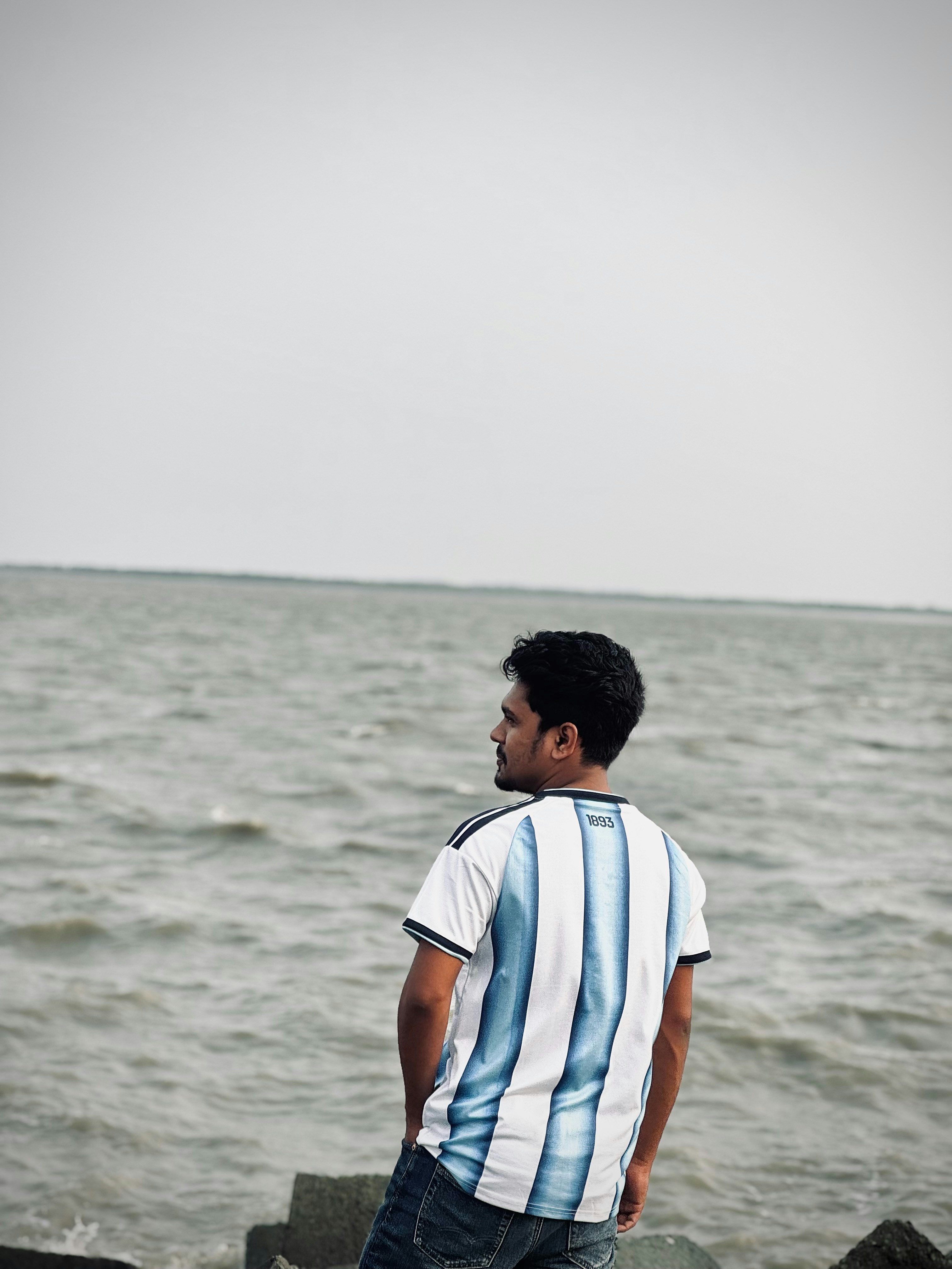 Stripes by the Shore: A Back-Faced Portrait Against the Sea