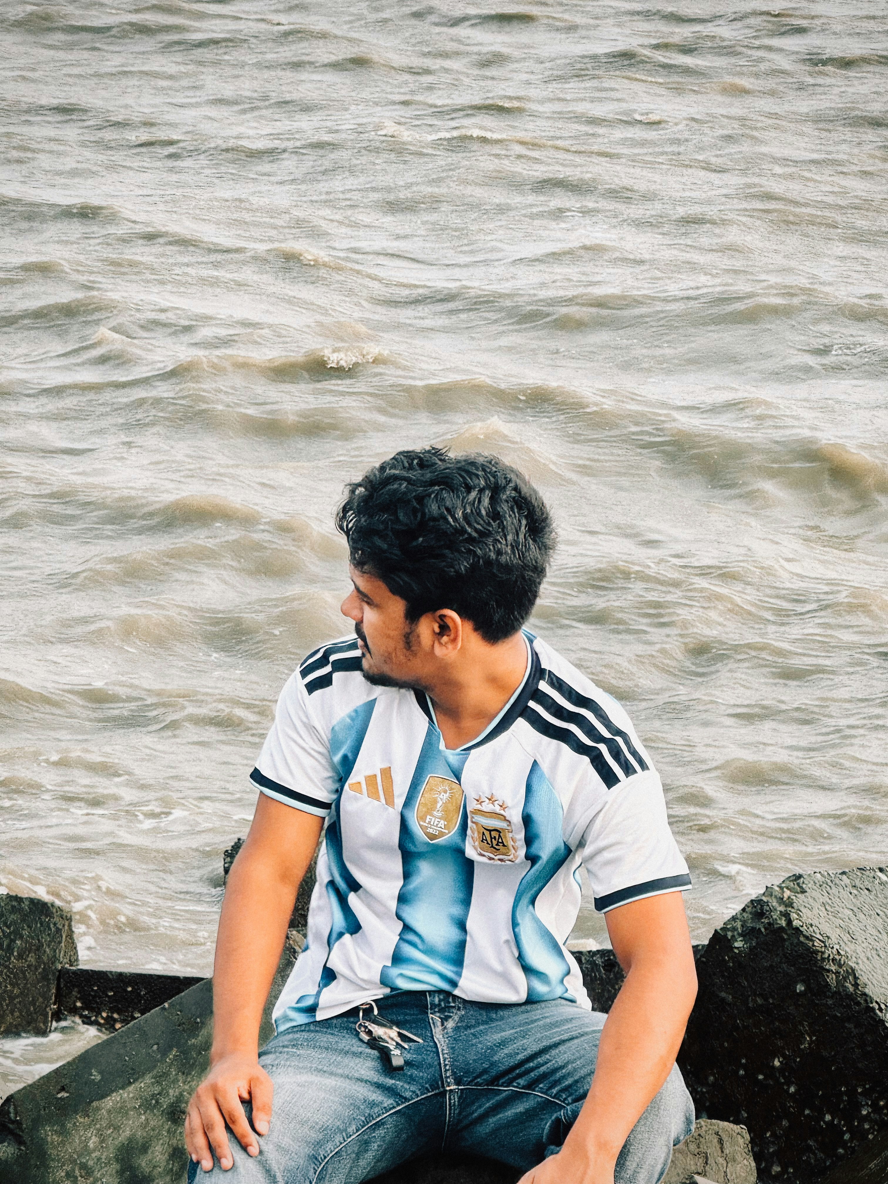 Seaside Portrait: A Man in Argentina's Striped Jersey by Flickering Waves