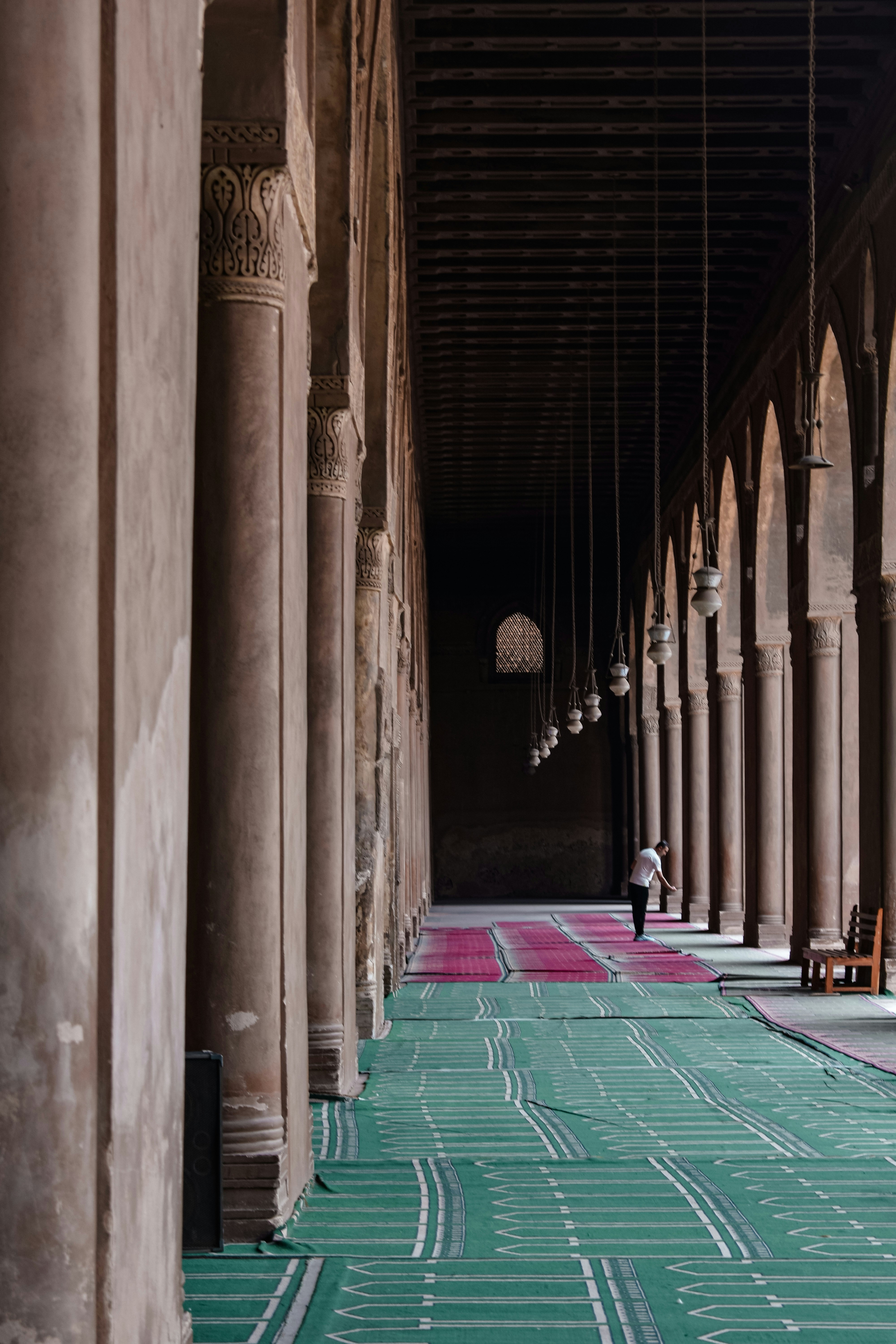 Colonnade Quiet: A Sole Visitor Walks the Long Hall