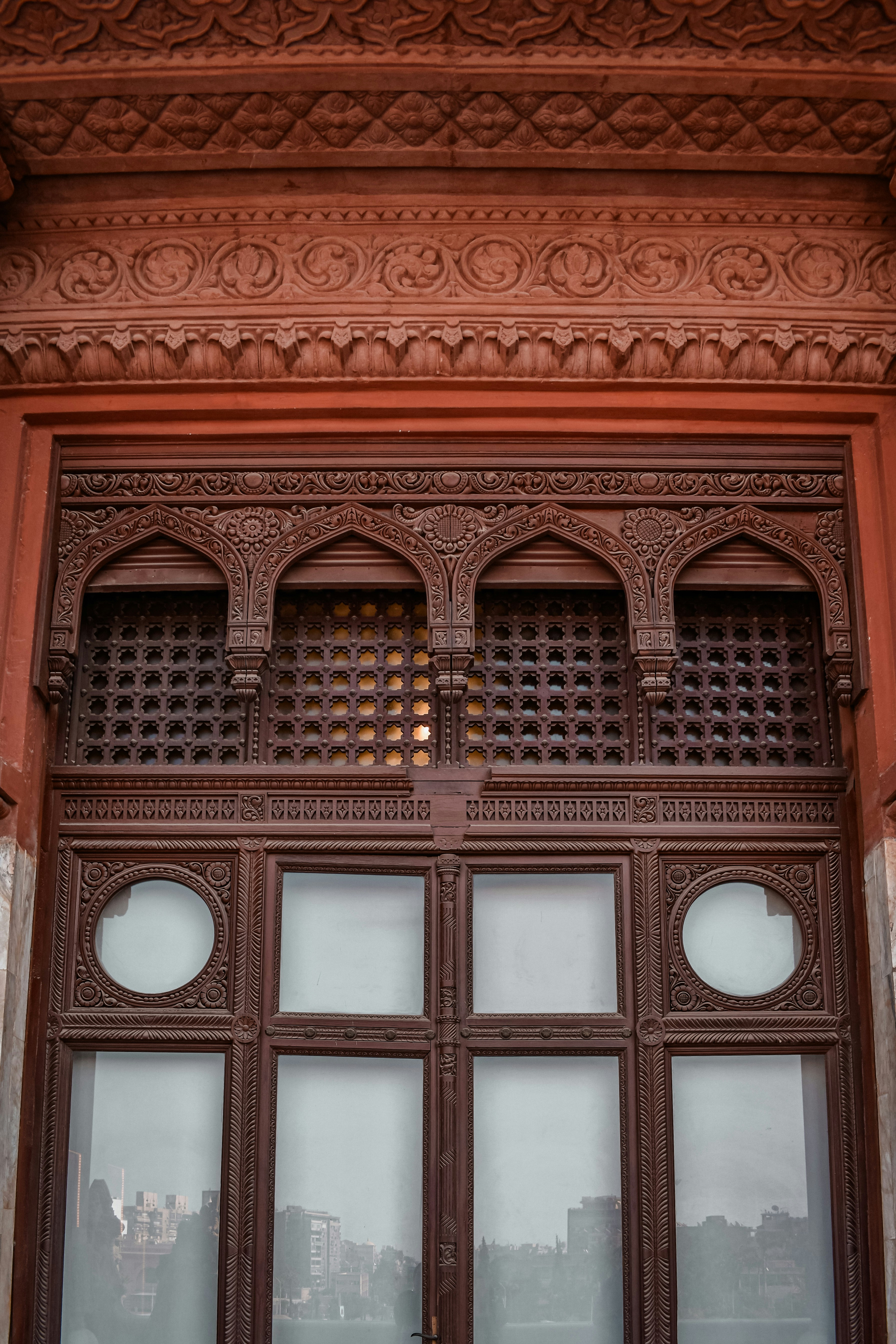 Carved Red Gateway: Intricate Archways Framing a Distant City