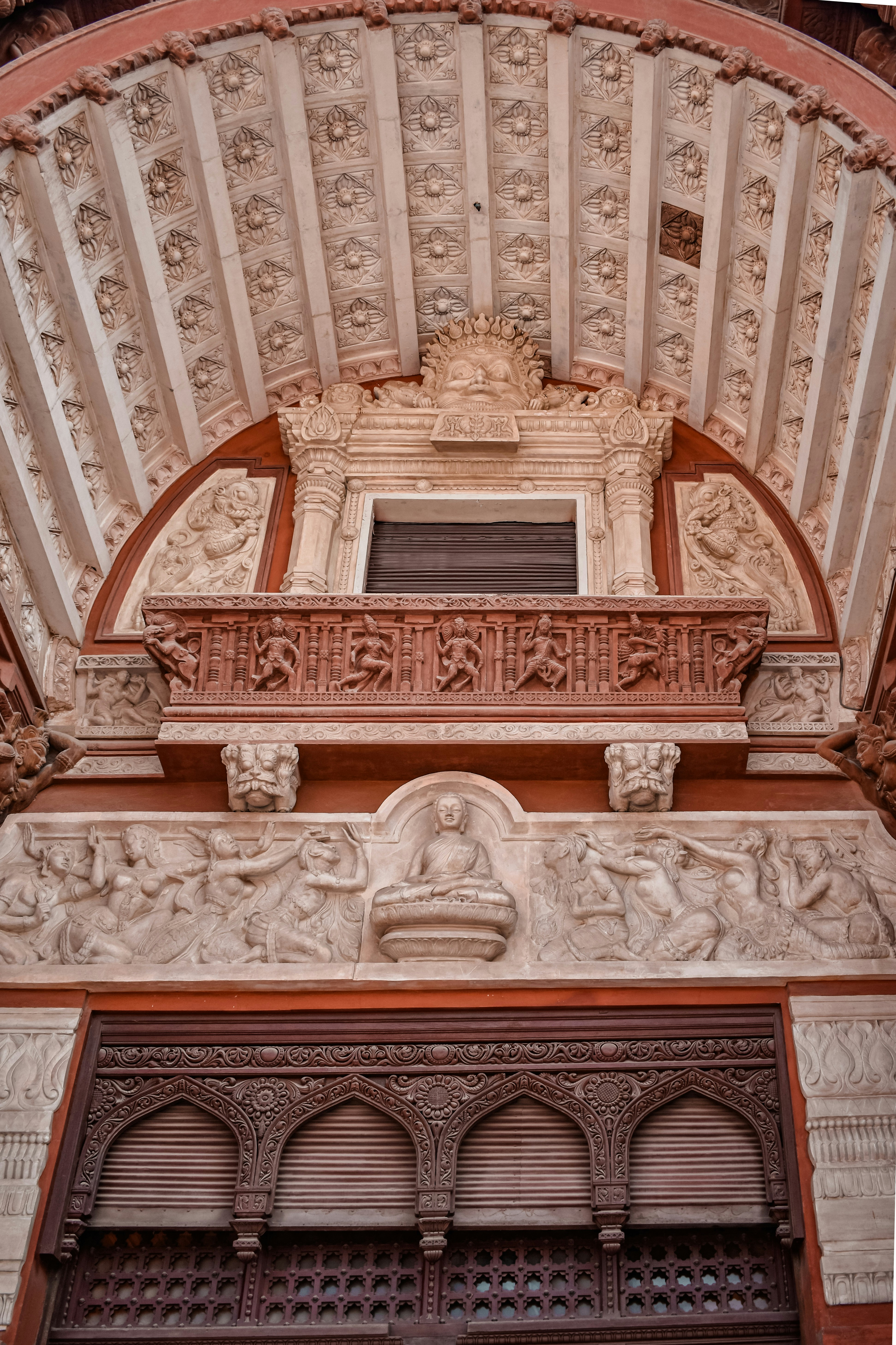 Ornate Archway and Relief Carvings Framing a Solemn Ceramic Bench
