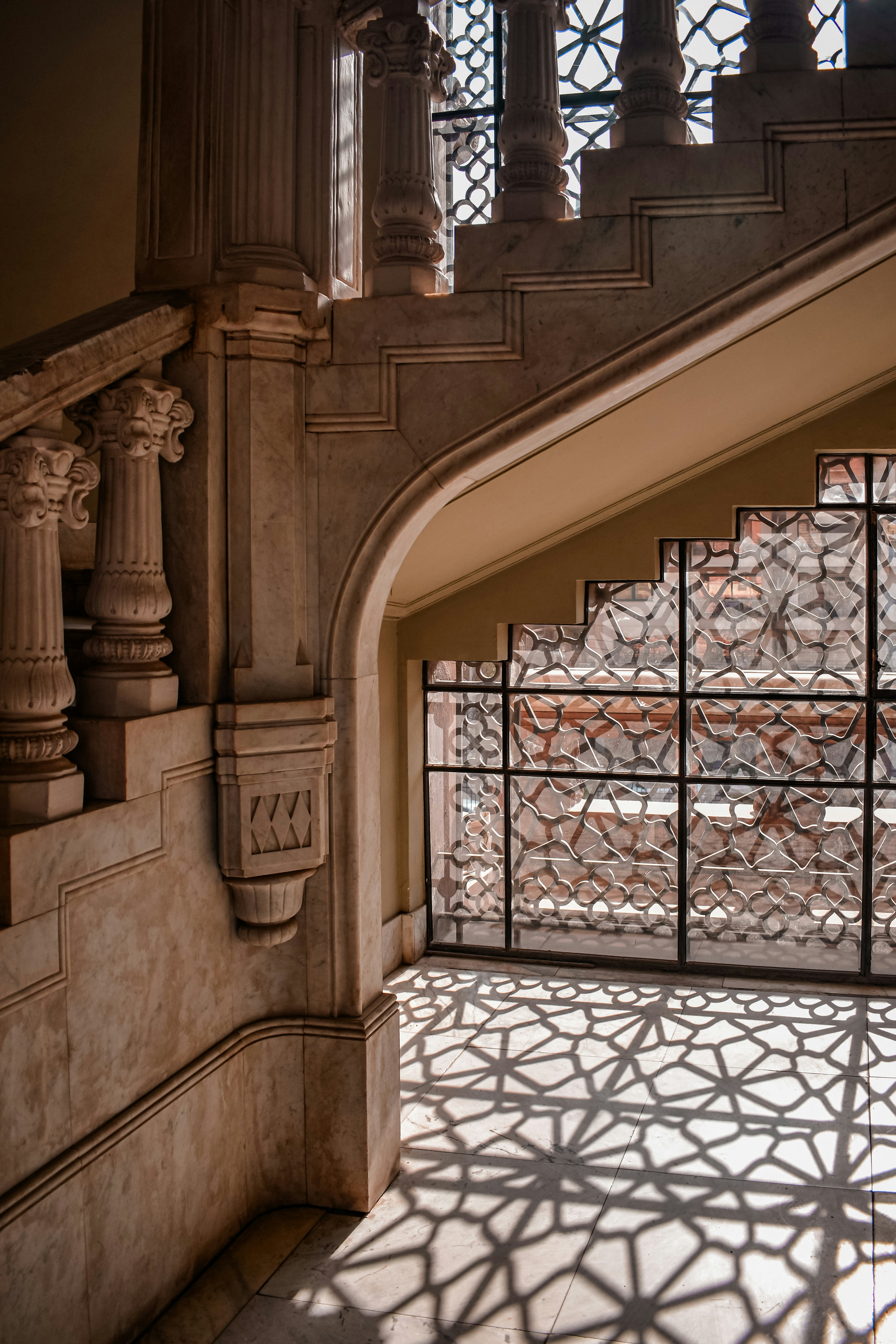 Shadowed Lattice: Sunlit Gratings Across Marble Stairway