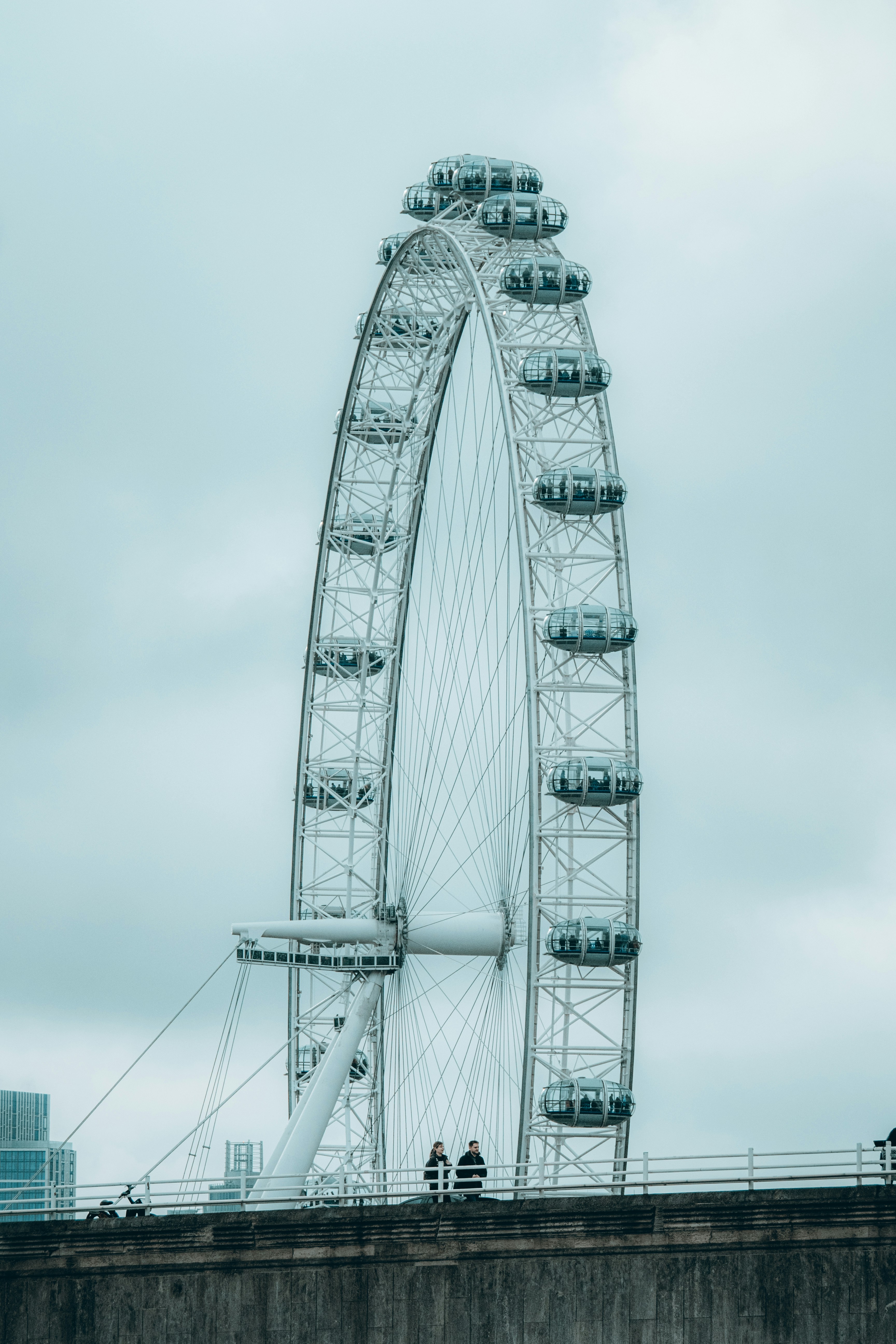 London Eye silhouette: two observers on the viewing deck beneath a pale sky