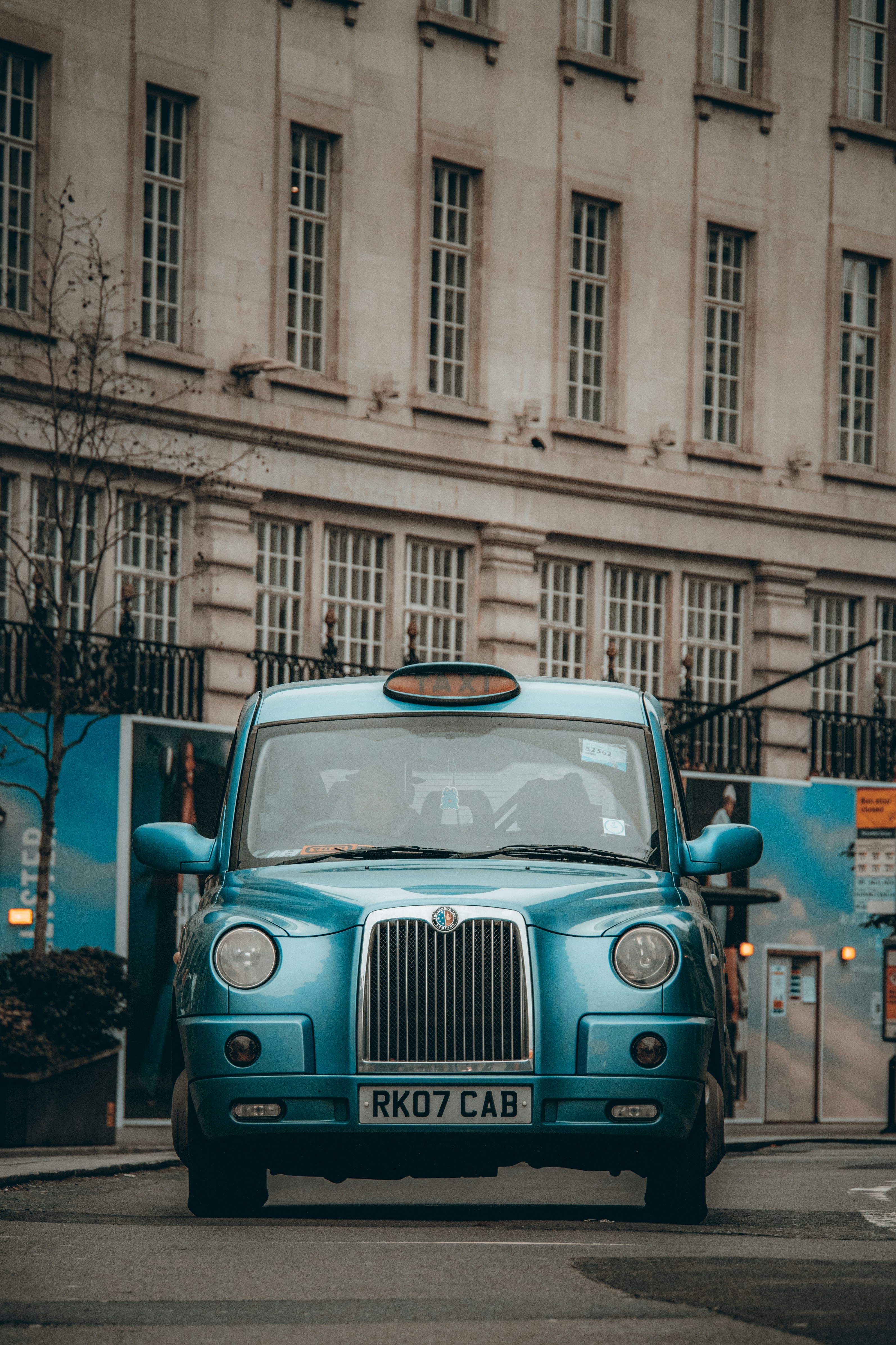 Blue taxi under a city facade: a bold street portrait