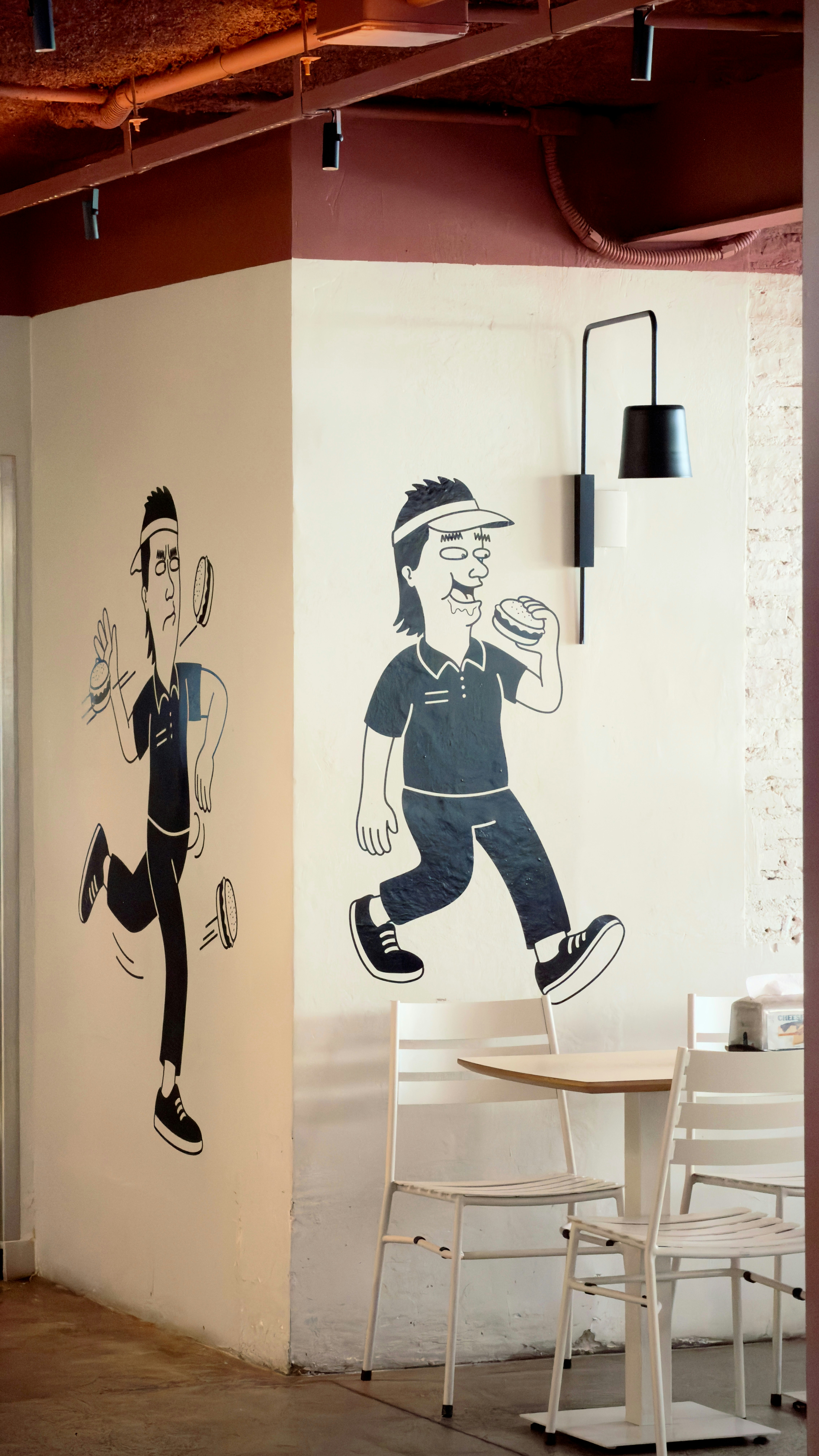Mirthful mural with two cartoon coffee-breakers at a sunlit cafe wall