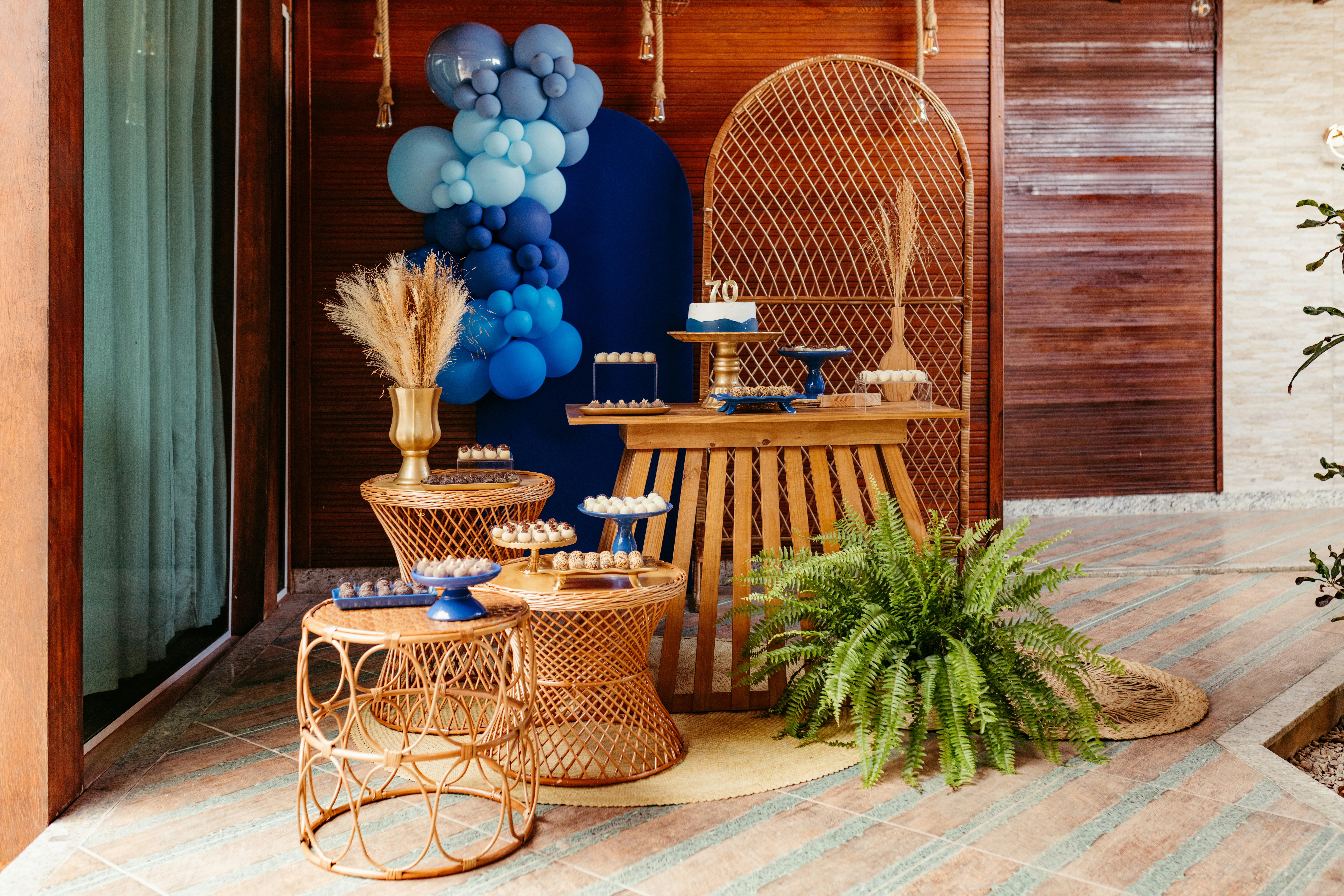 Delicate dessert altar with blue balloon bouquet and woven furniture