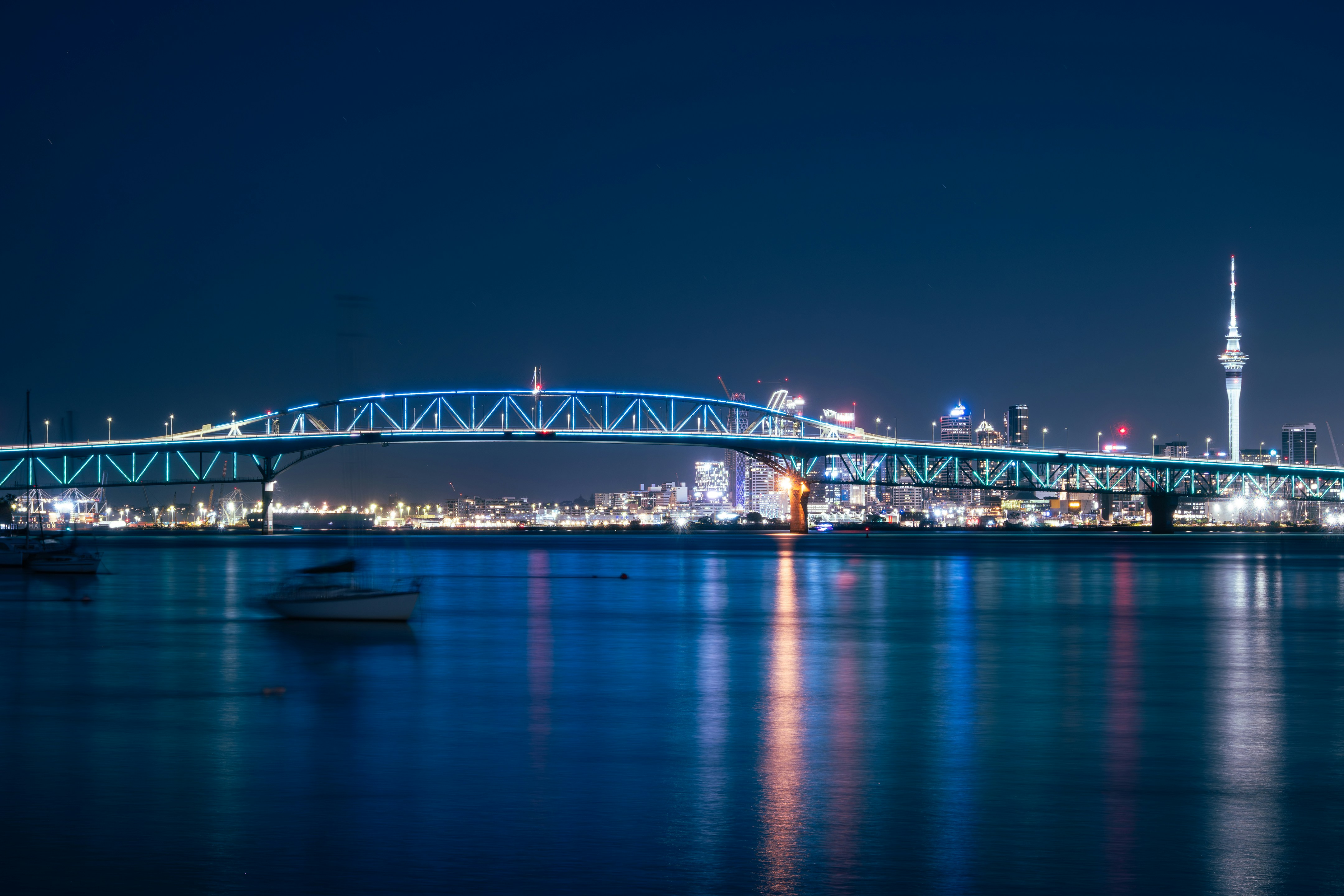 Neon River Crossing: Nighttime Skyline over Calm Waters