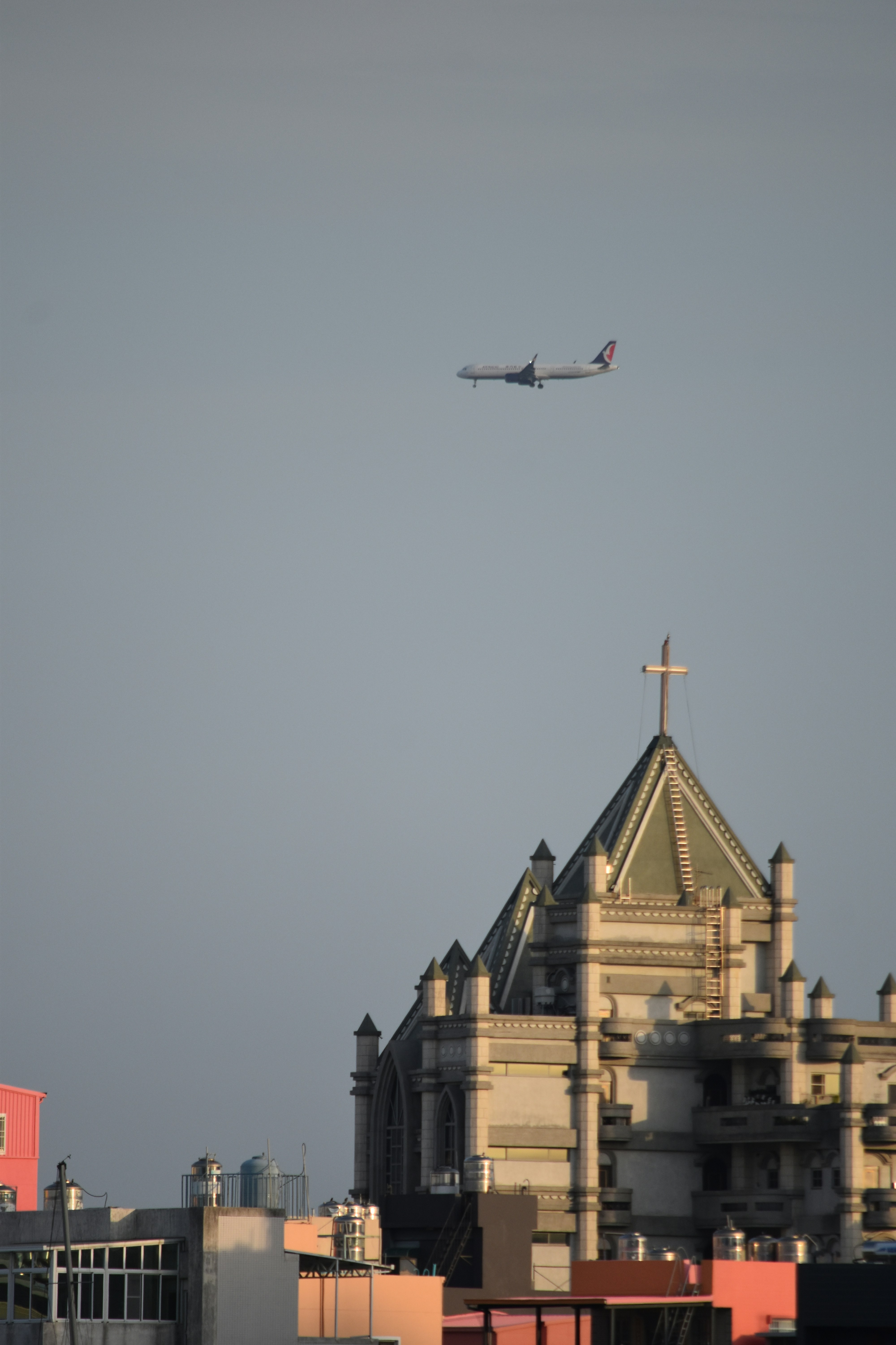 Airliner Above Sacred Facade: A City Church with Aircraft in the Distance