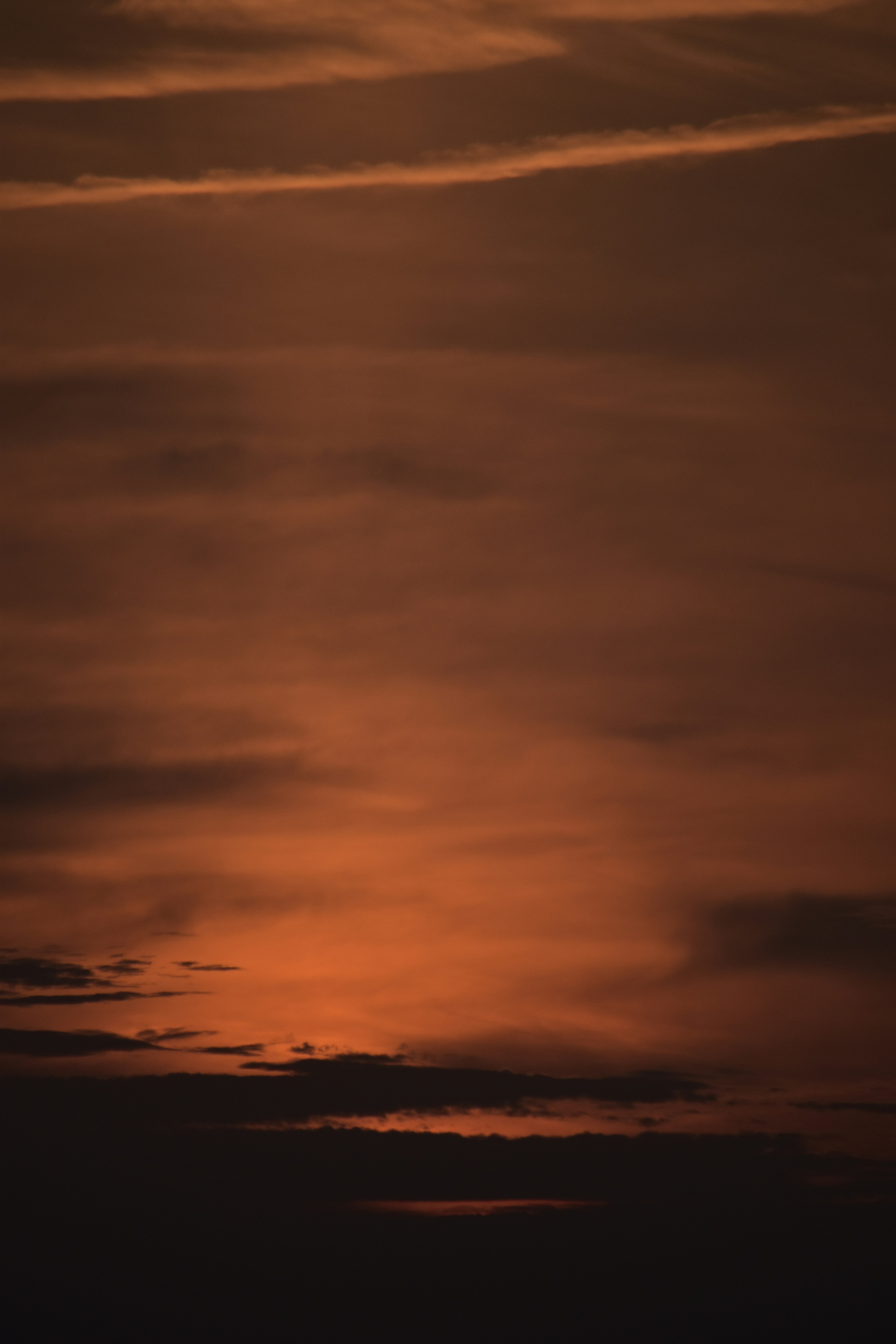 Amber Horizon: Quiet Sunset Over Darkened Clouds
