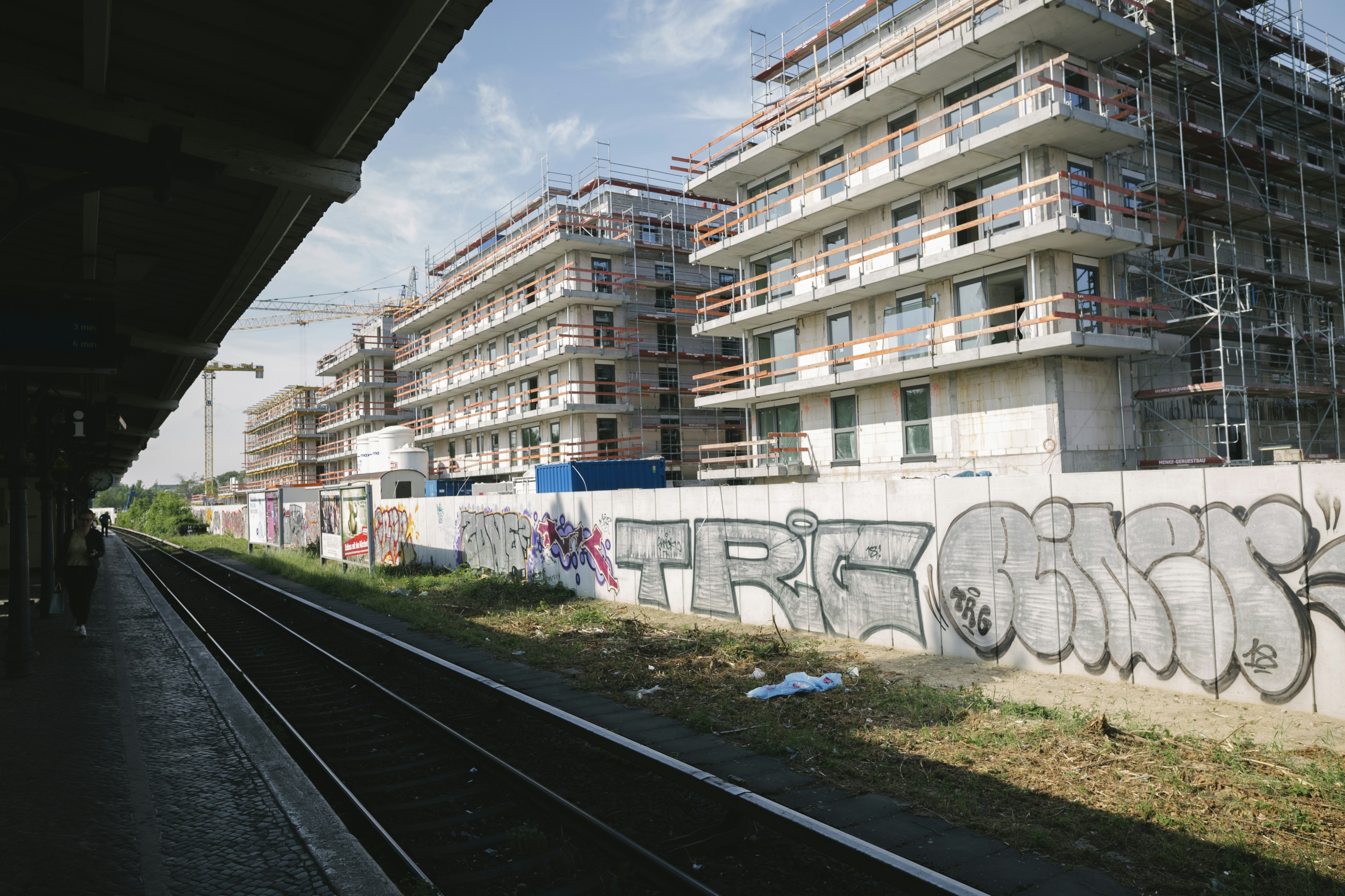 Graffiti Wall Looms Over a Building Site Along an Empty Train Platform