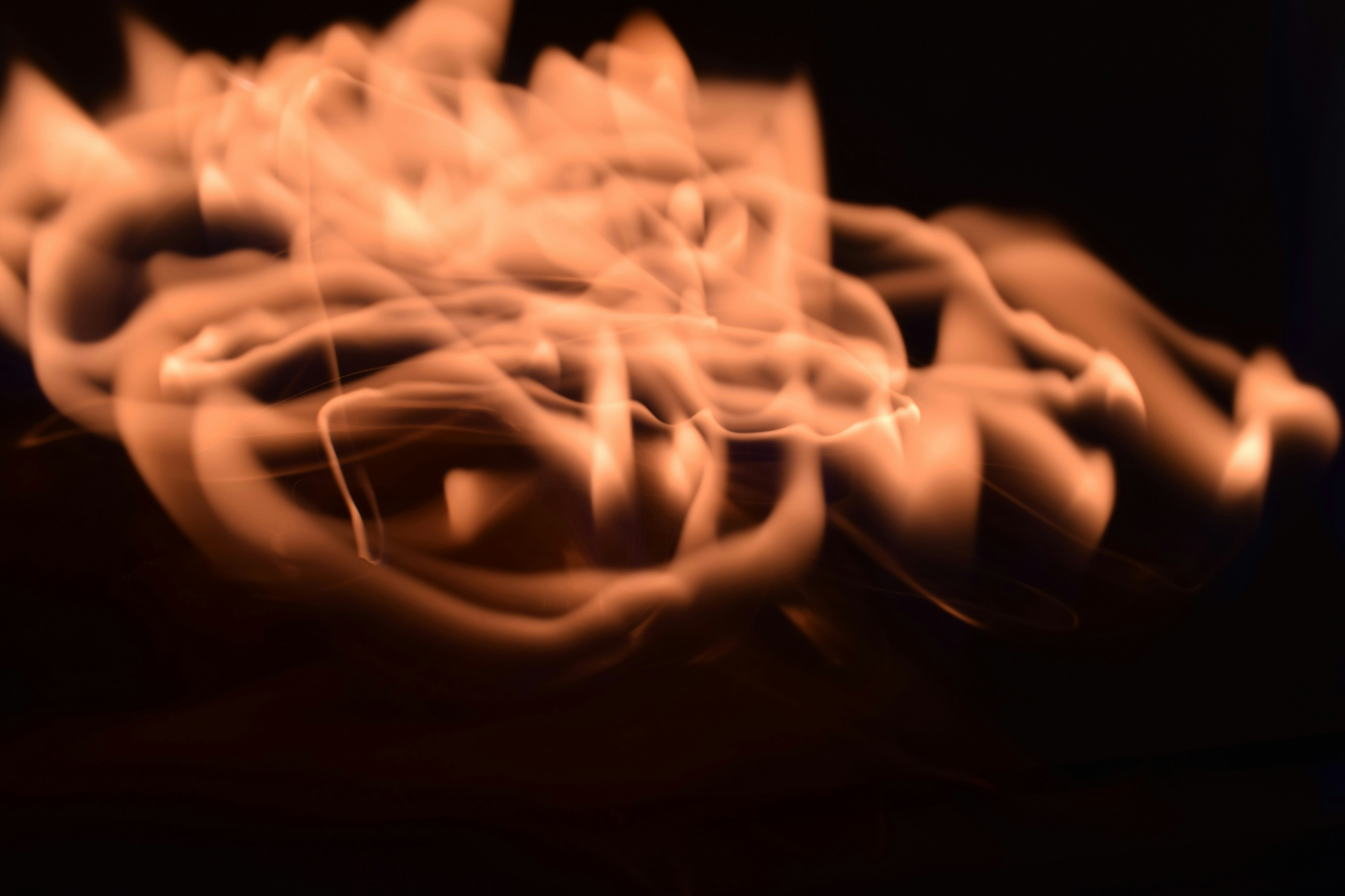 Flames in Motion: Abstract Orange Whorls Against Velvet Darkness