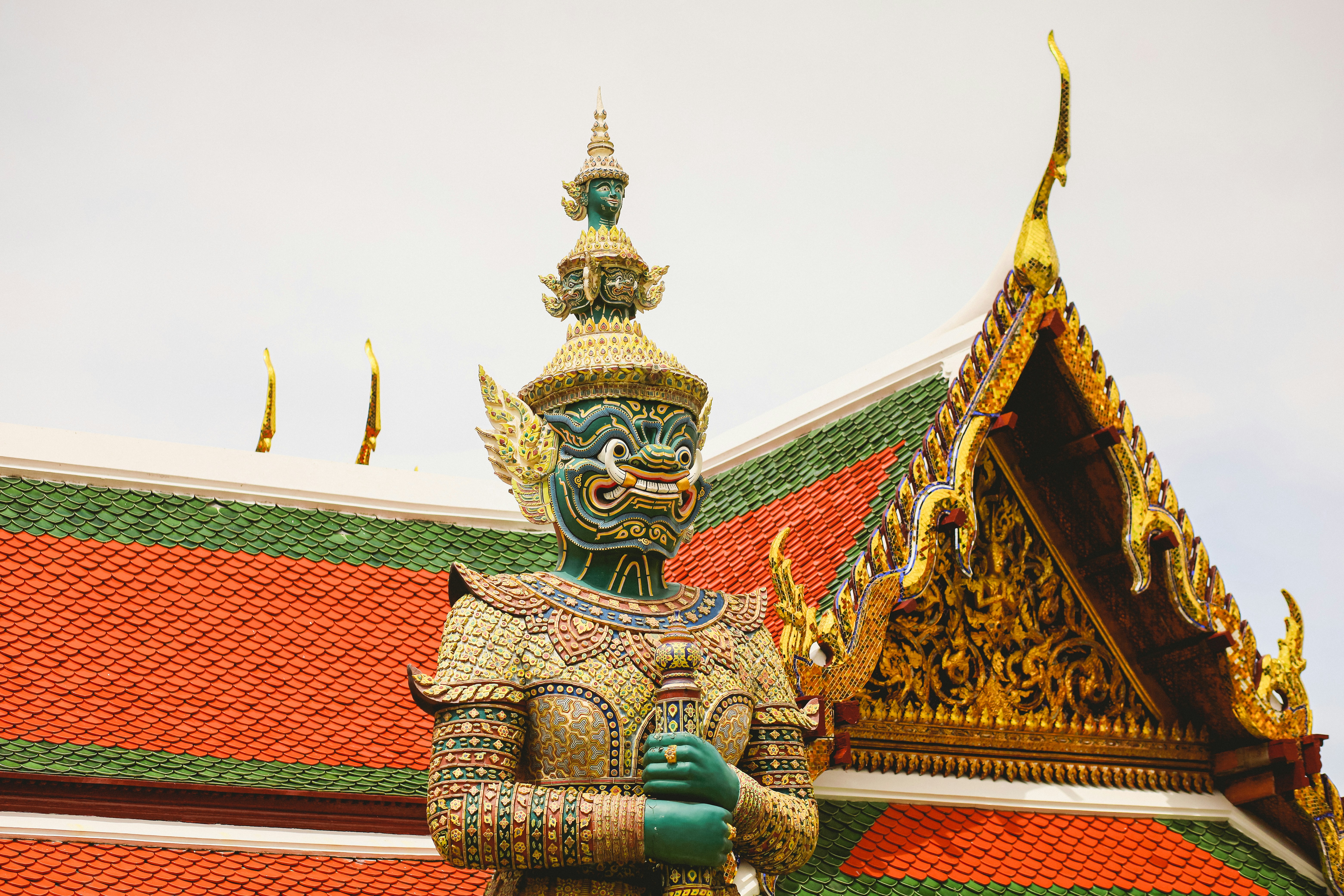 Guard of the Gate: jeweled guardian statue at temple eaves