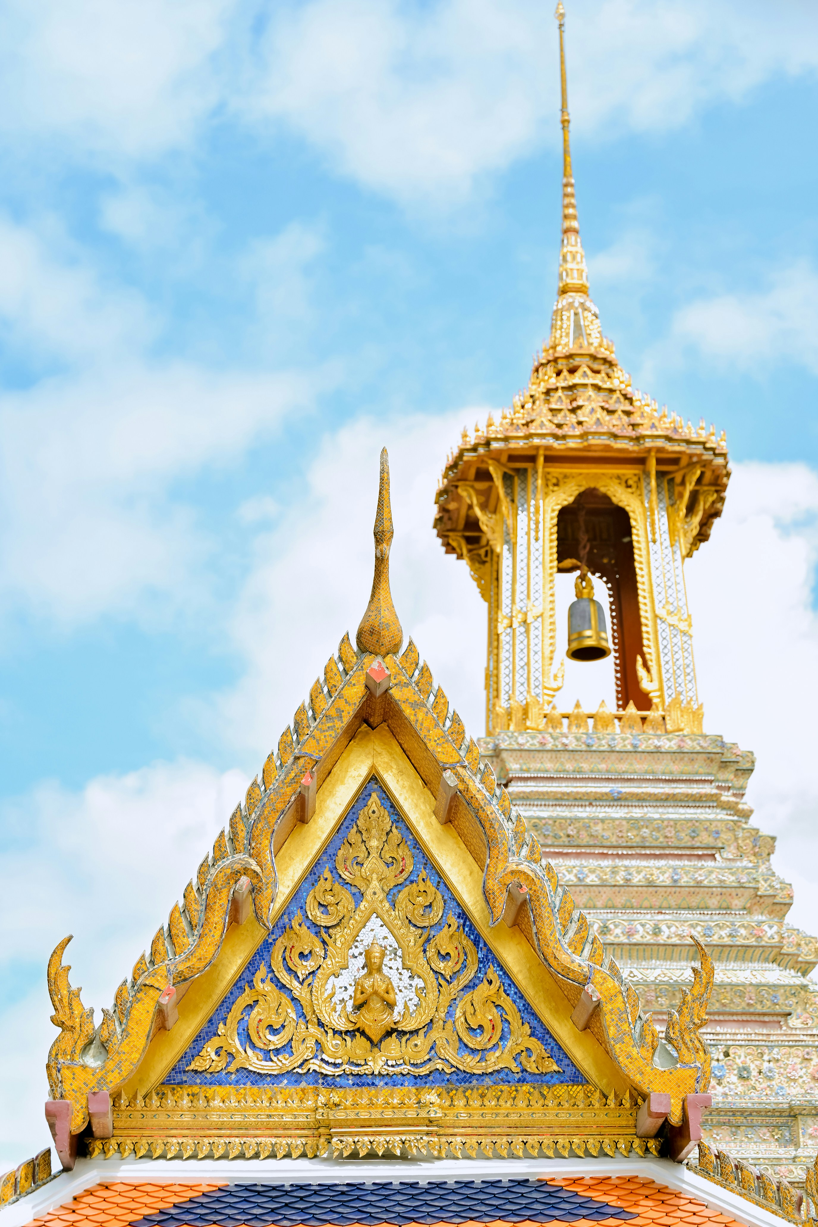 Golden Temple Frieze: A Sunlit Turret Ascends Above Ornate Roofing