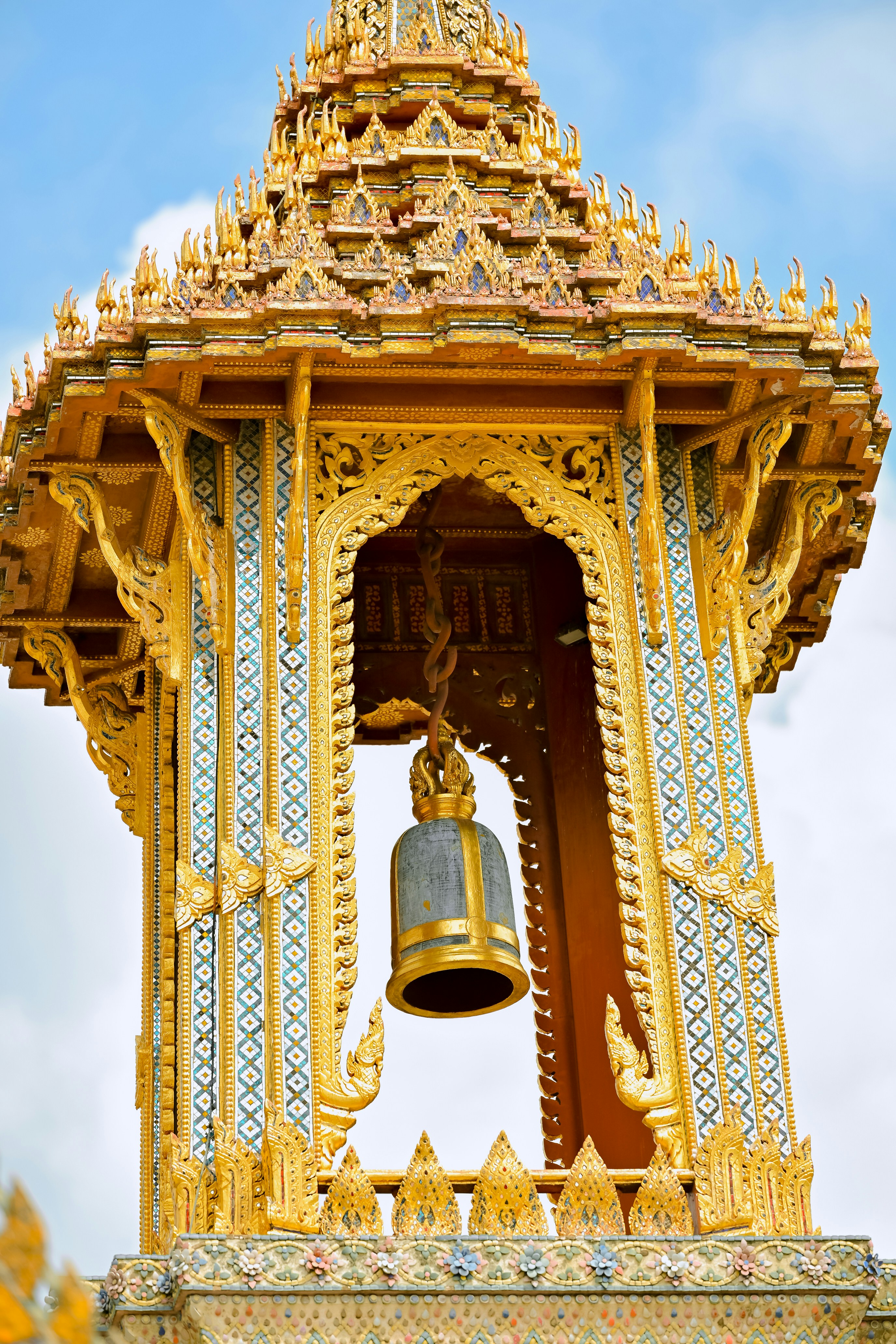 Golden Bell Tower: Ornate Thai Temple Detail in Bright Sky