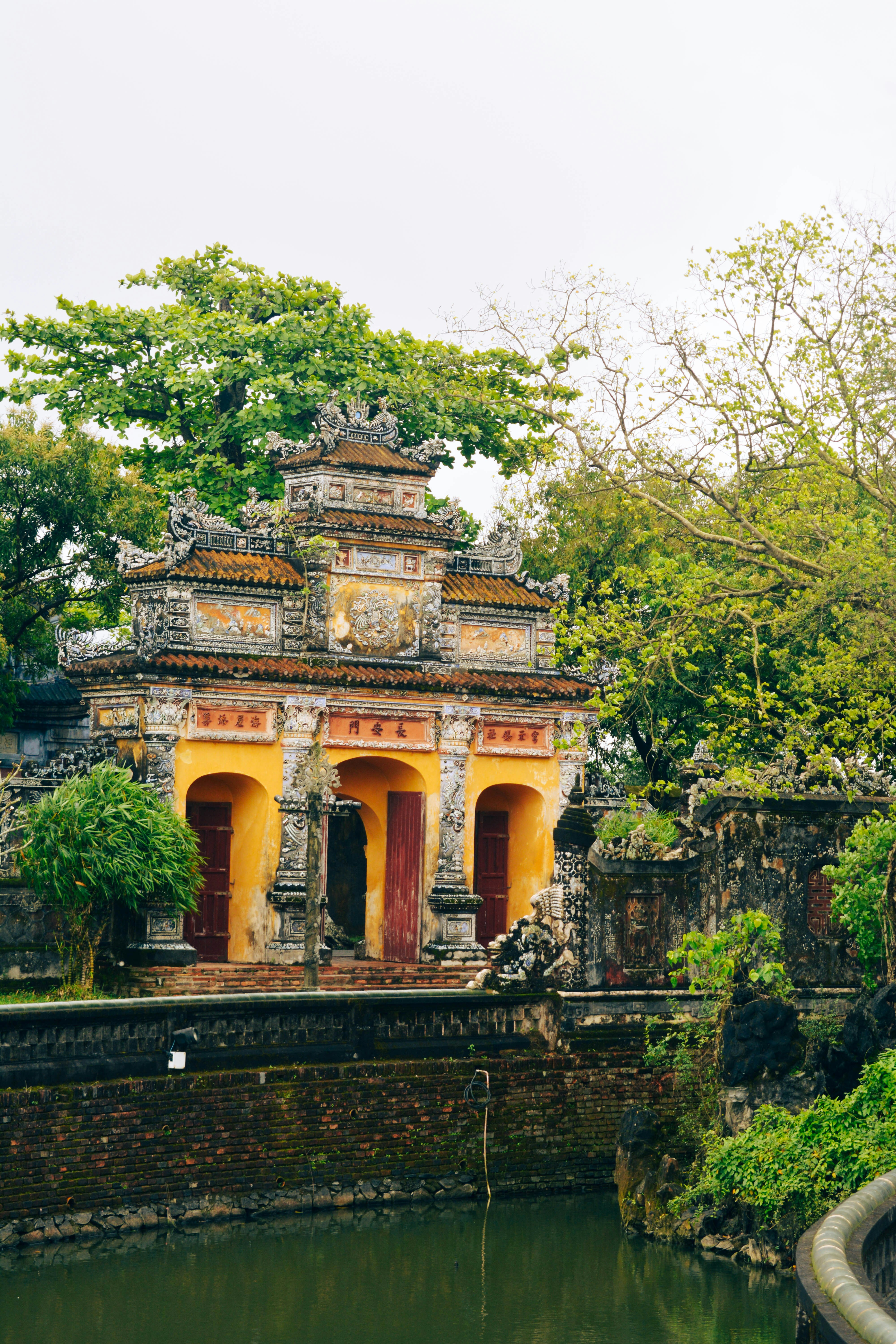 Sunlit Gateways: A Historic Vietnamese Temple Cresting the Water