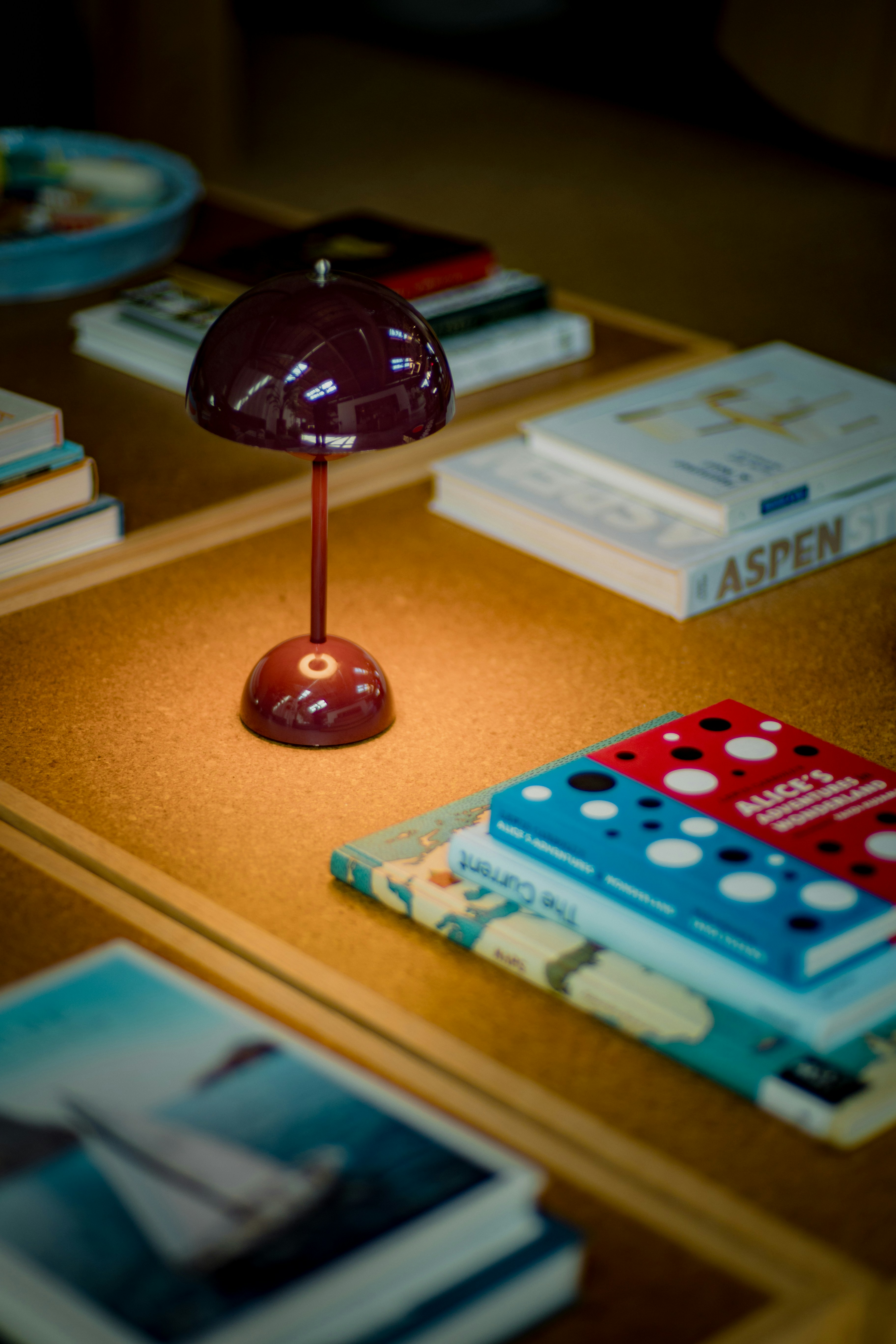 Miniature lamp on a study desk casting a warm glow over stacked books