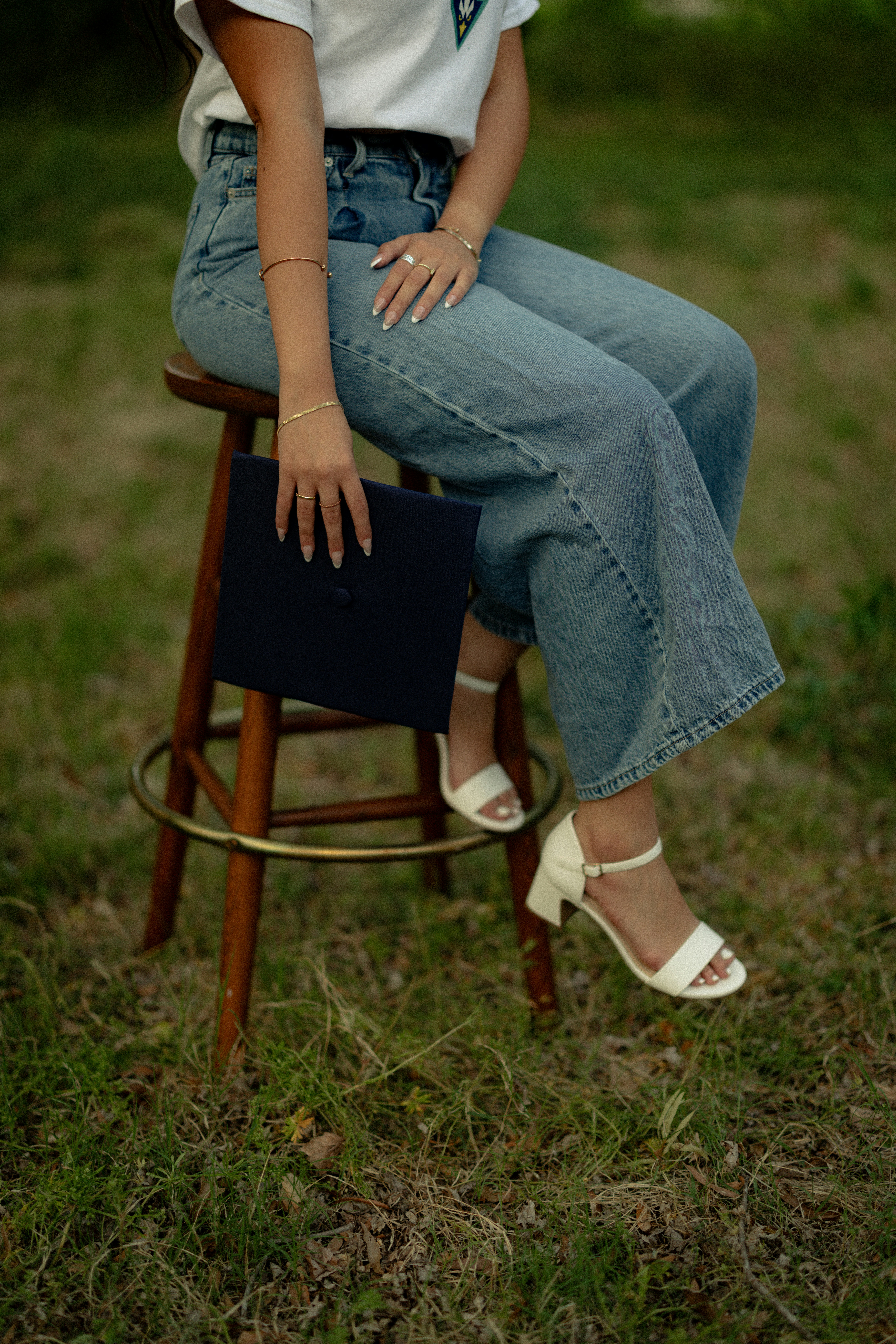 Softly Poised in Denim: A Quiet Moment on a Wooden Stool