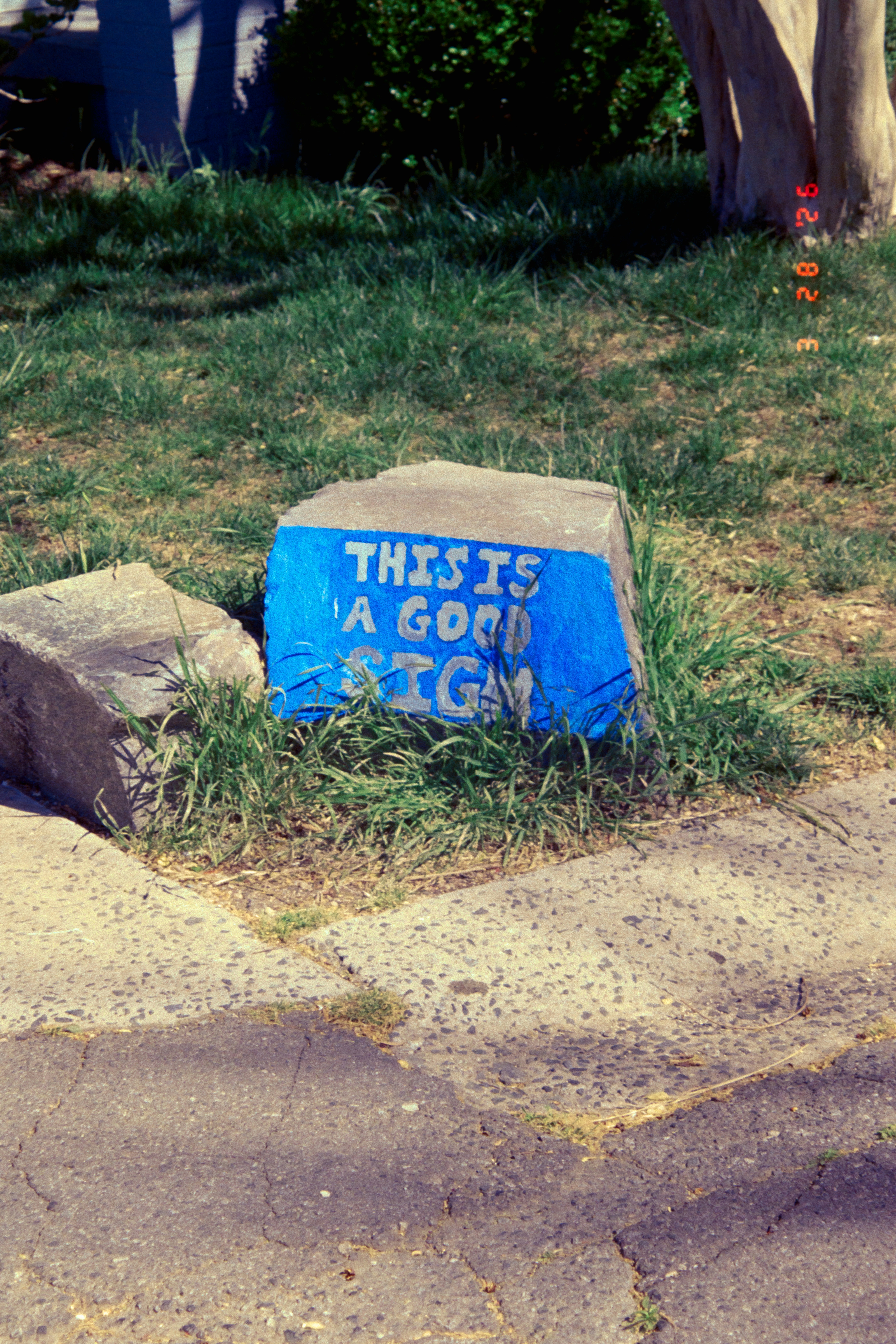 Graffiti Rock: A Blue Square with a Message on the Lawn