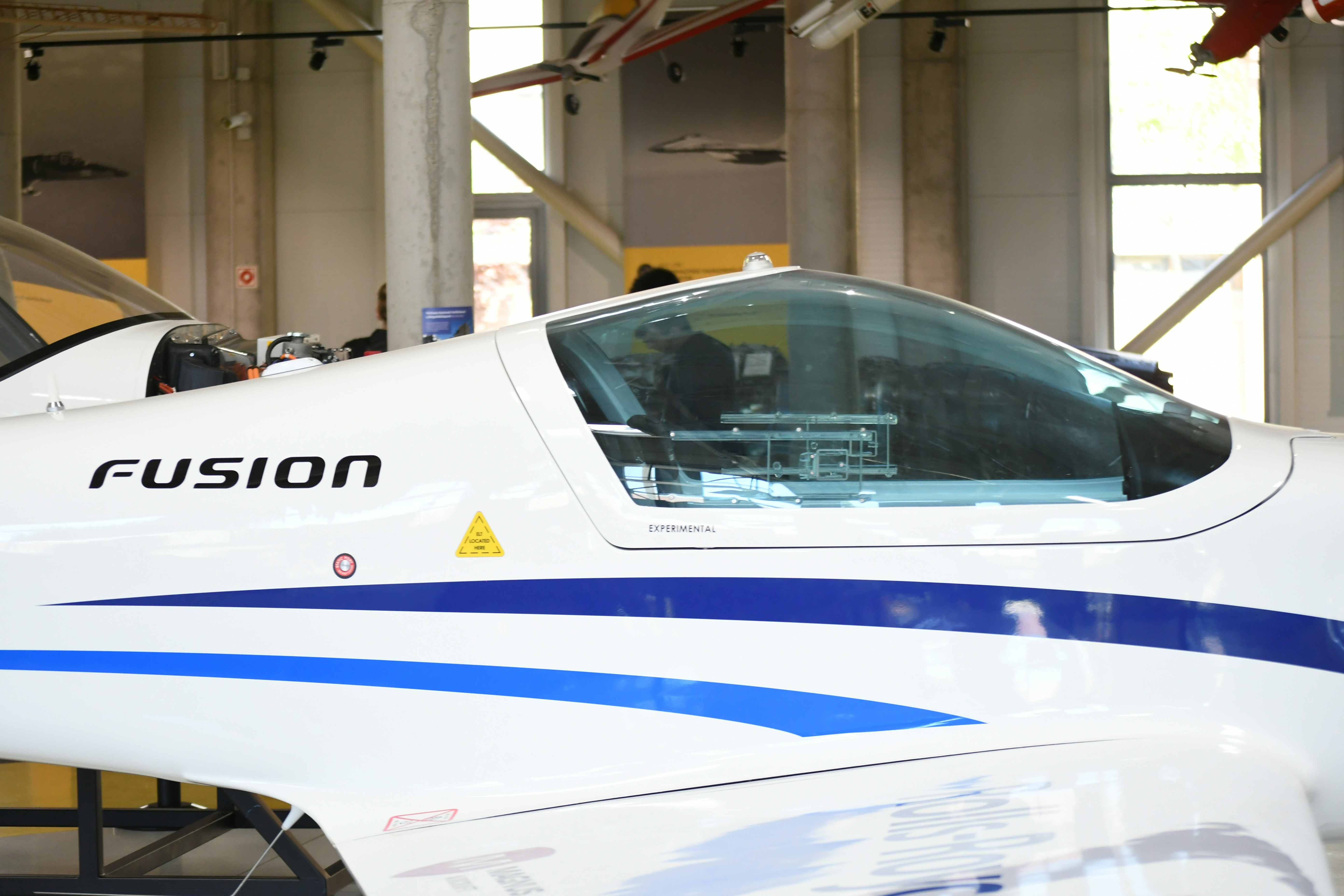 Fusion glider in a hangar: close-up of the cockpit and side logo