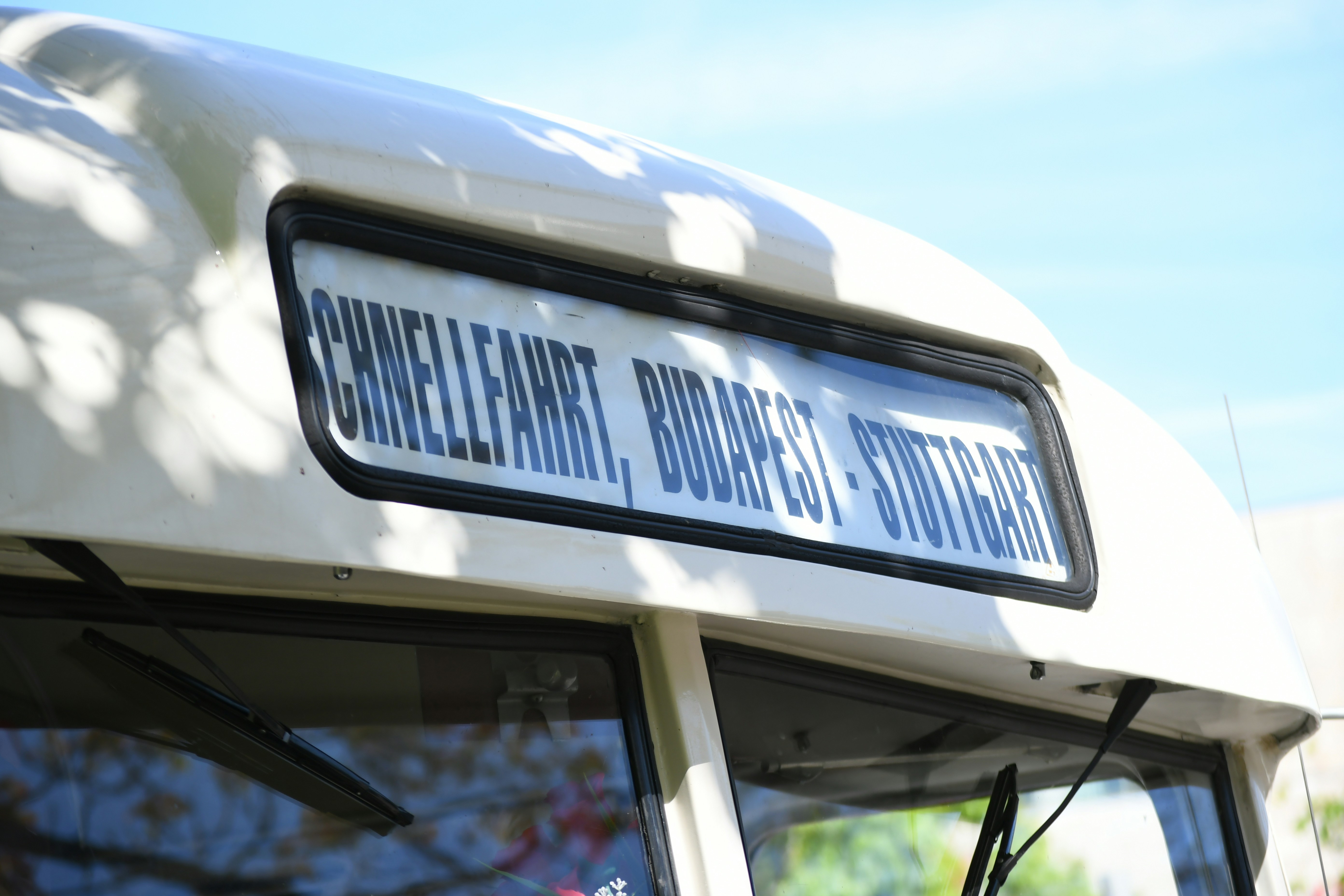 Signage on a vintage bus front catching dappled light