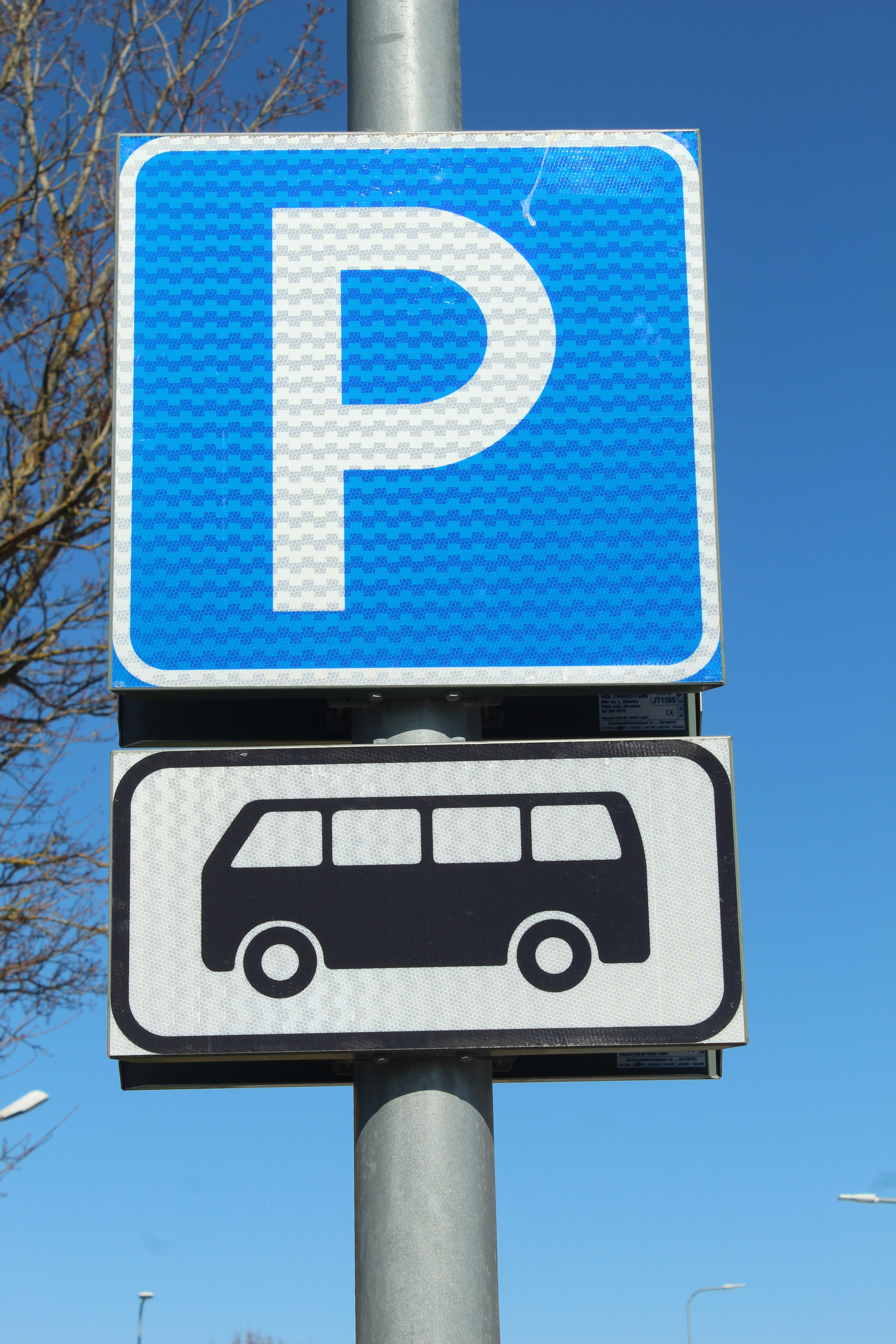 Blue Parking Sign With Bus Stop Emblem on a Metal Pole