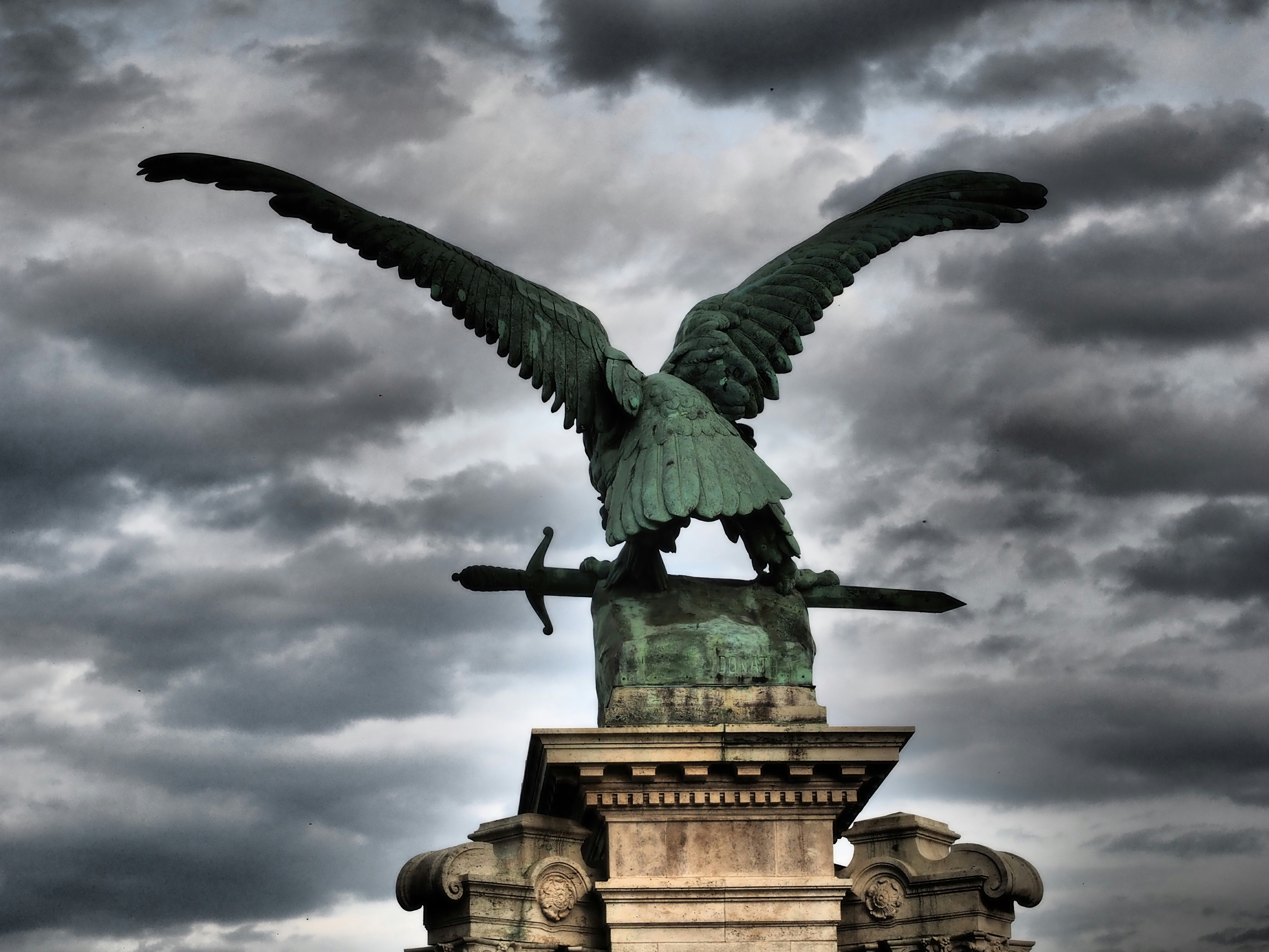Shadowed Guardian: Eagle Statue Soaring Above Marble Plinth