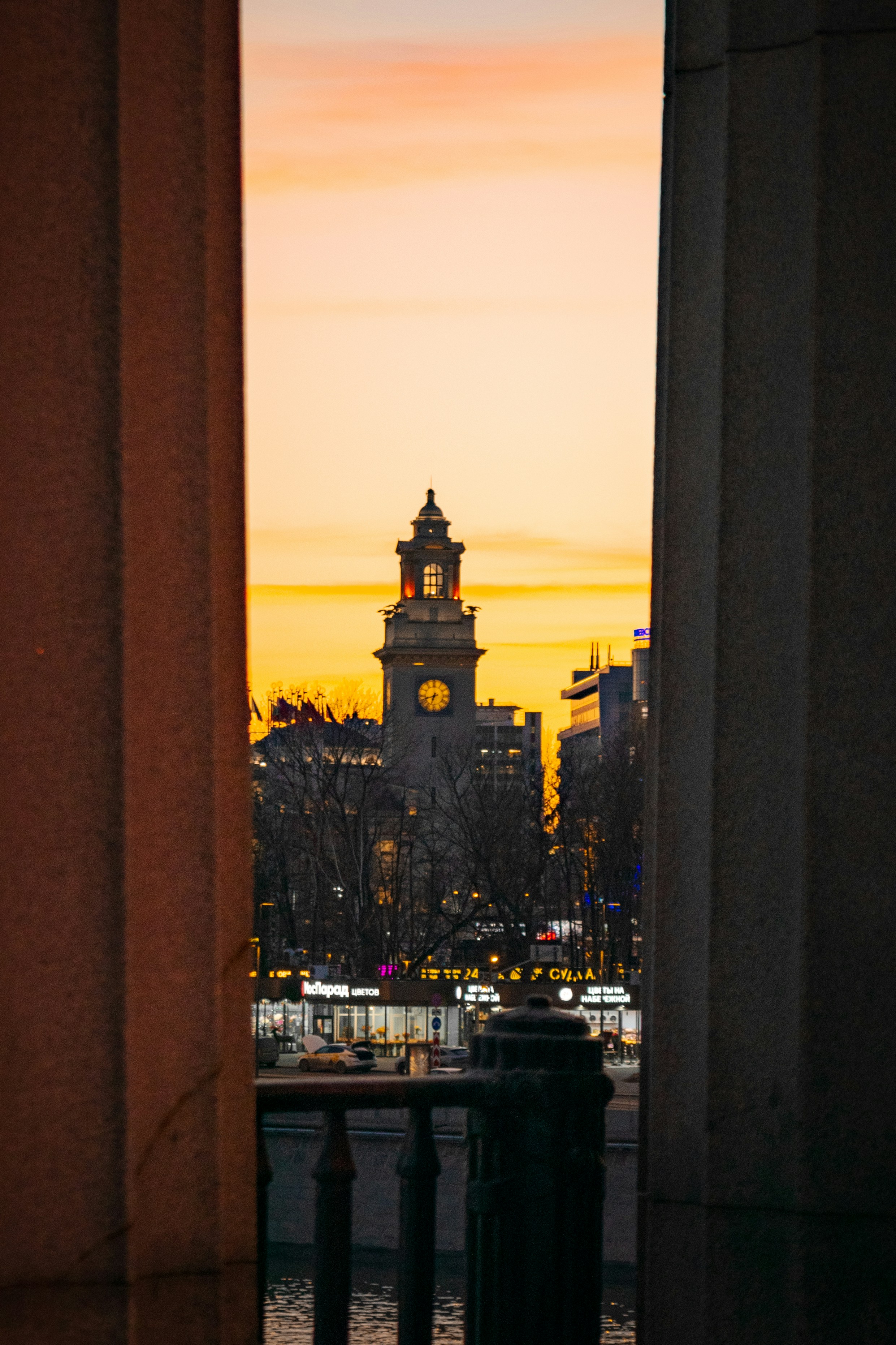 Clock Tower in the Golden Hour Between Vertical Columns