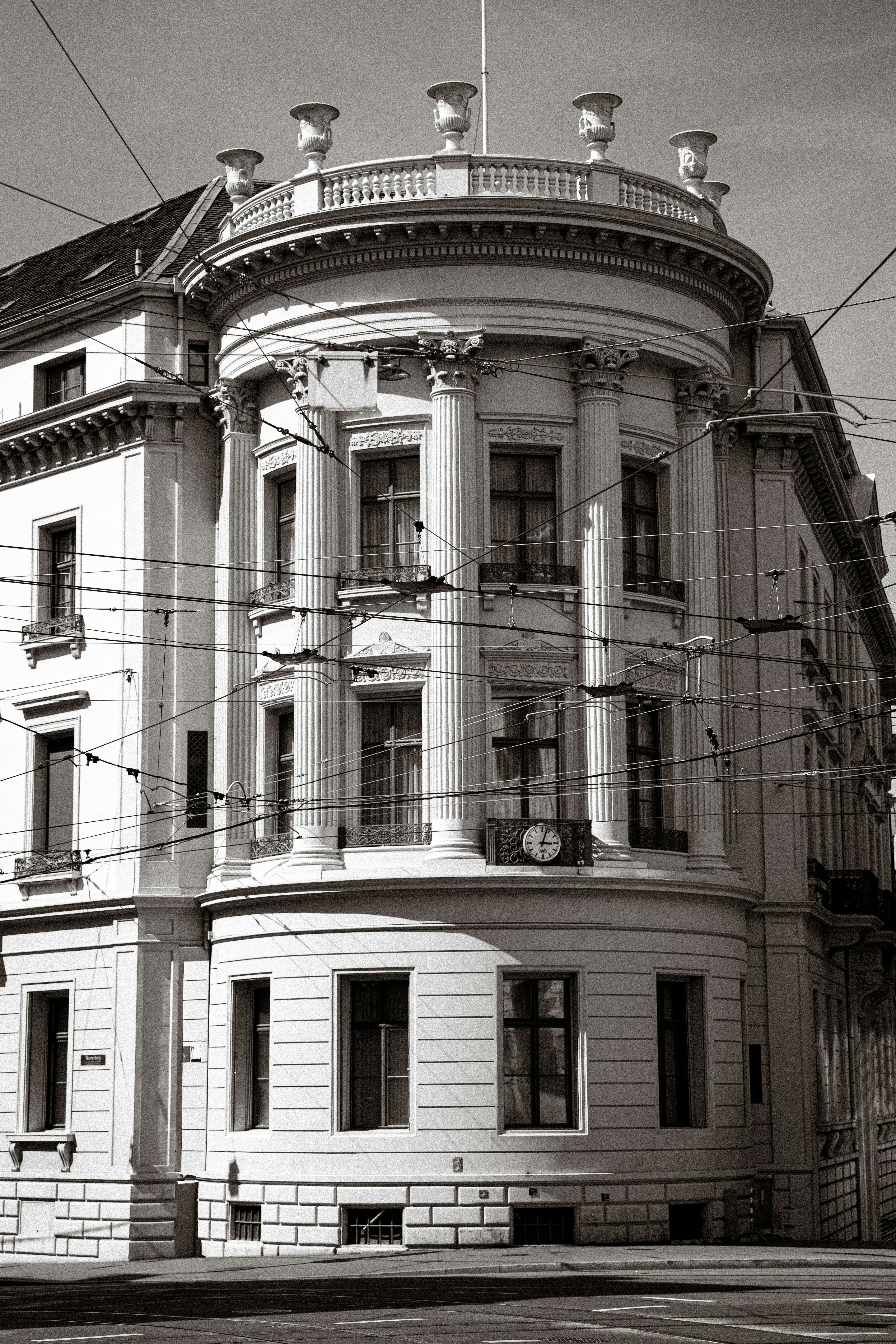 Historic Corner Curves: A Sunlit Facade with Ornate Balcony Columns