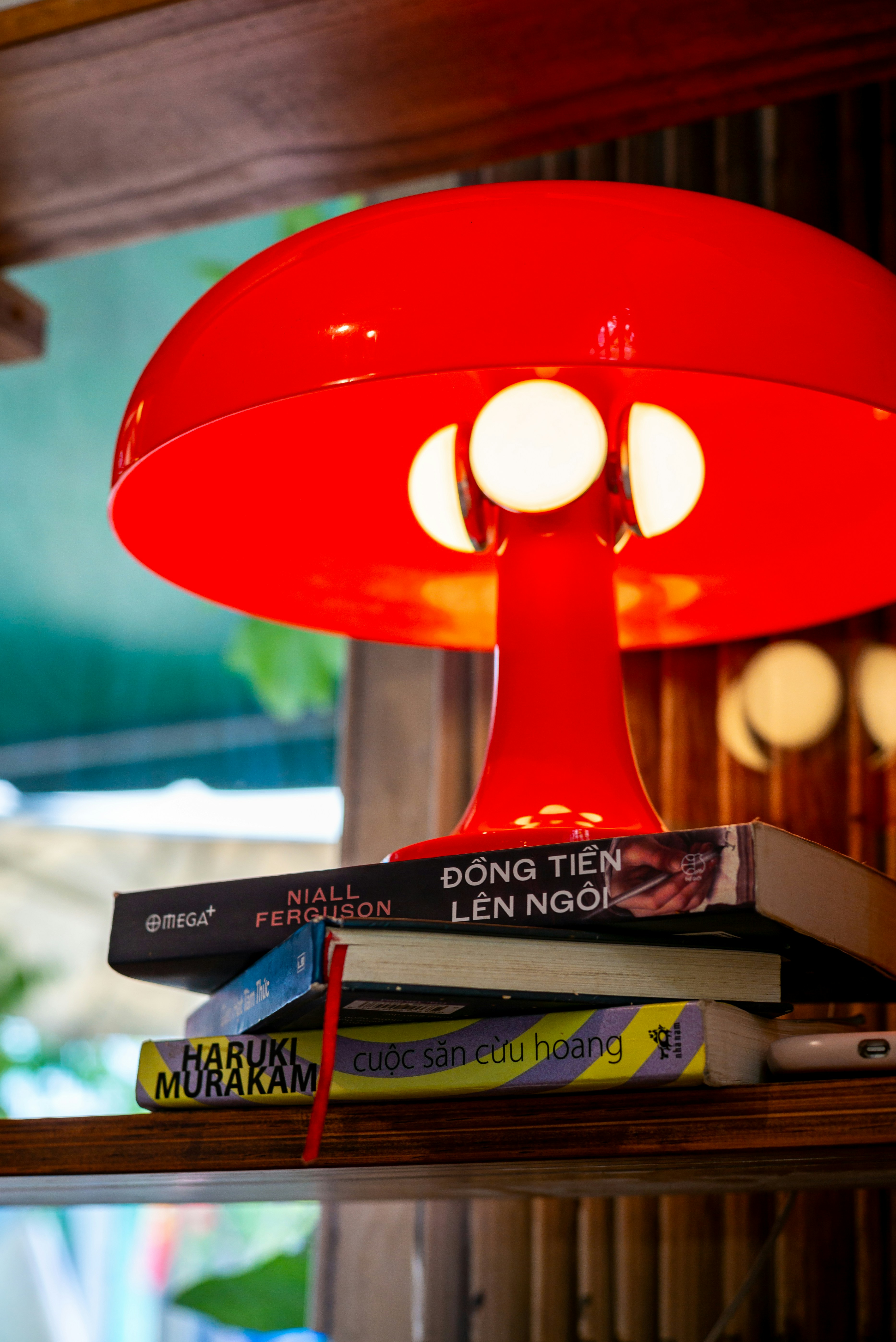 Red Lamp on a Stacked Shelf of Books Inside a Cozy Corner