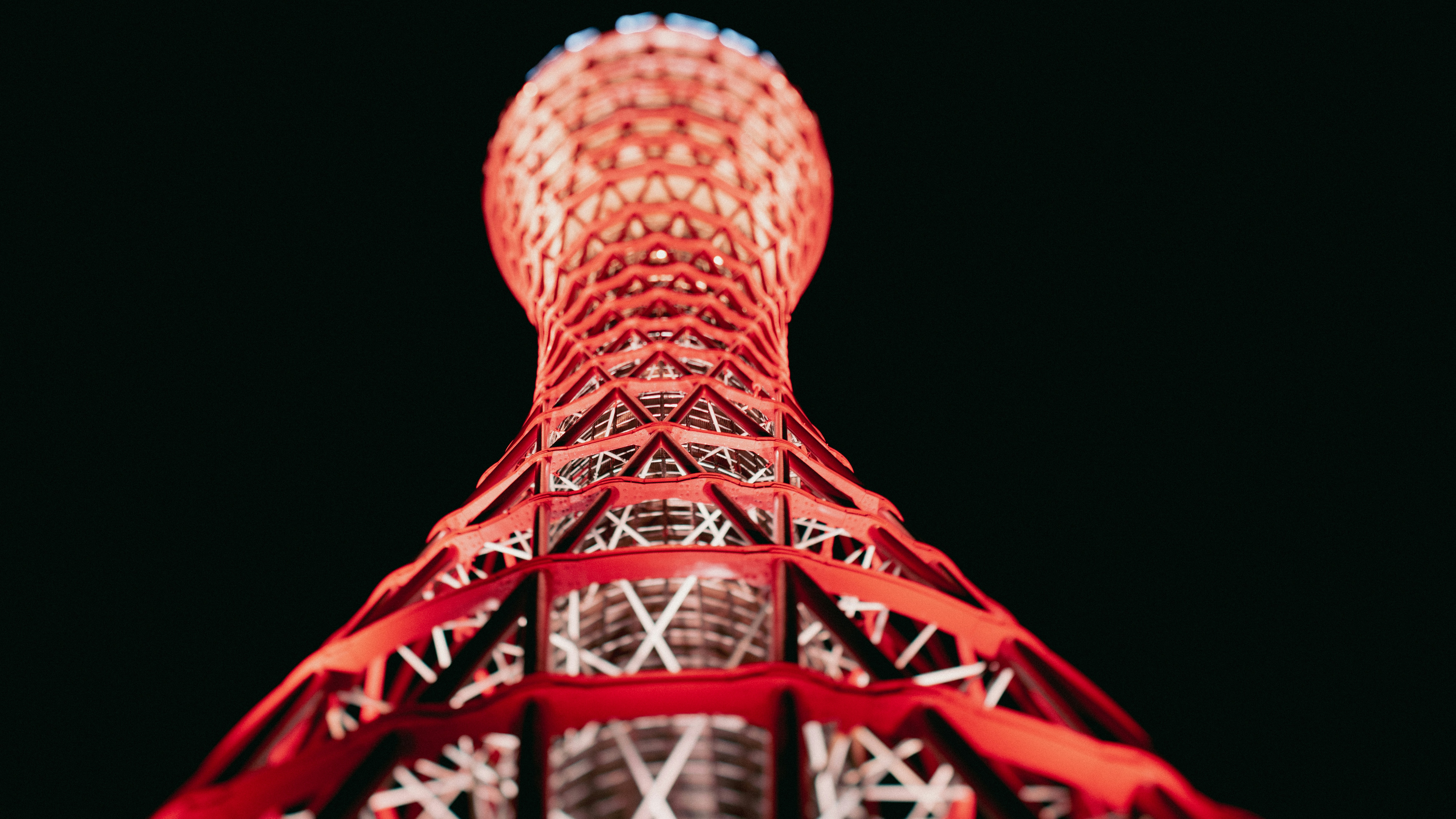 Red Lattice Tower Reaching into Night