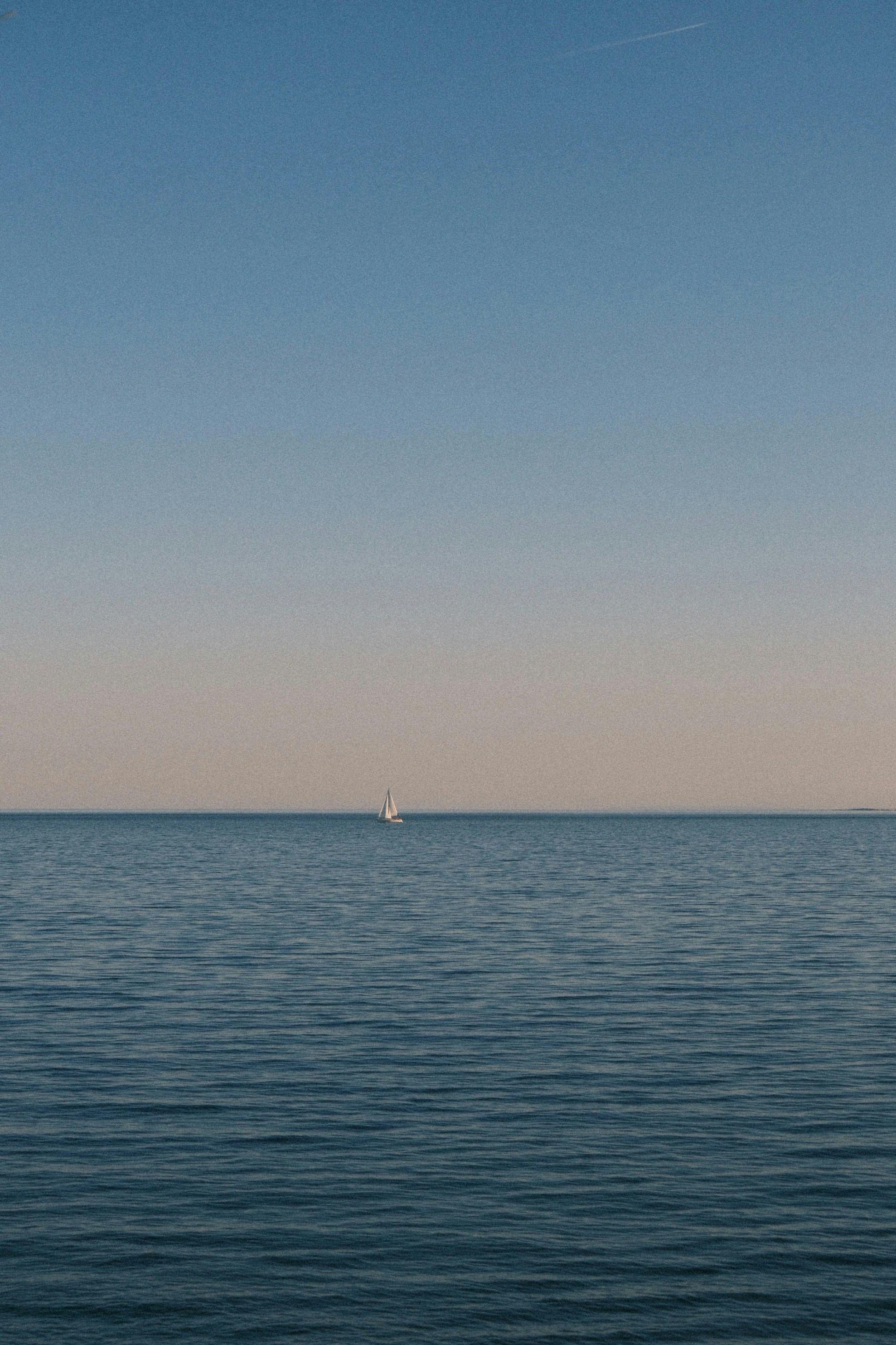 A Lone Sailboat on a Quiet Horizon