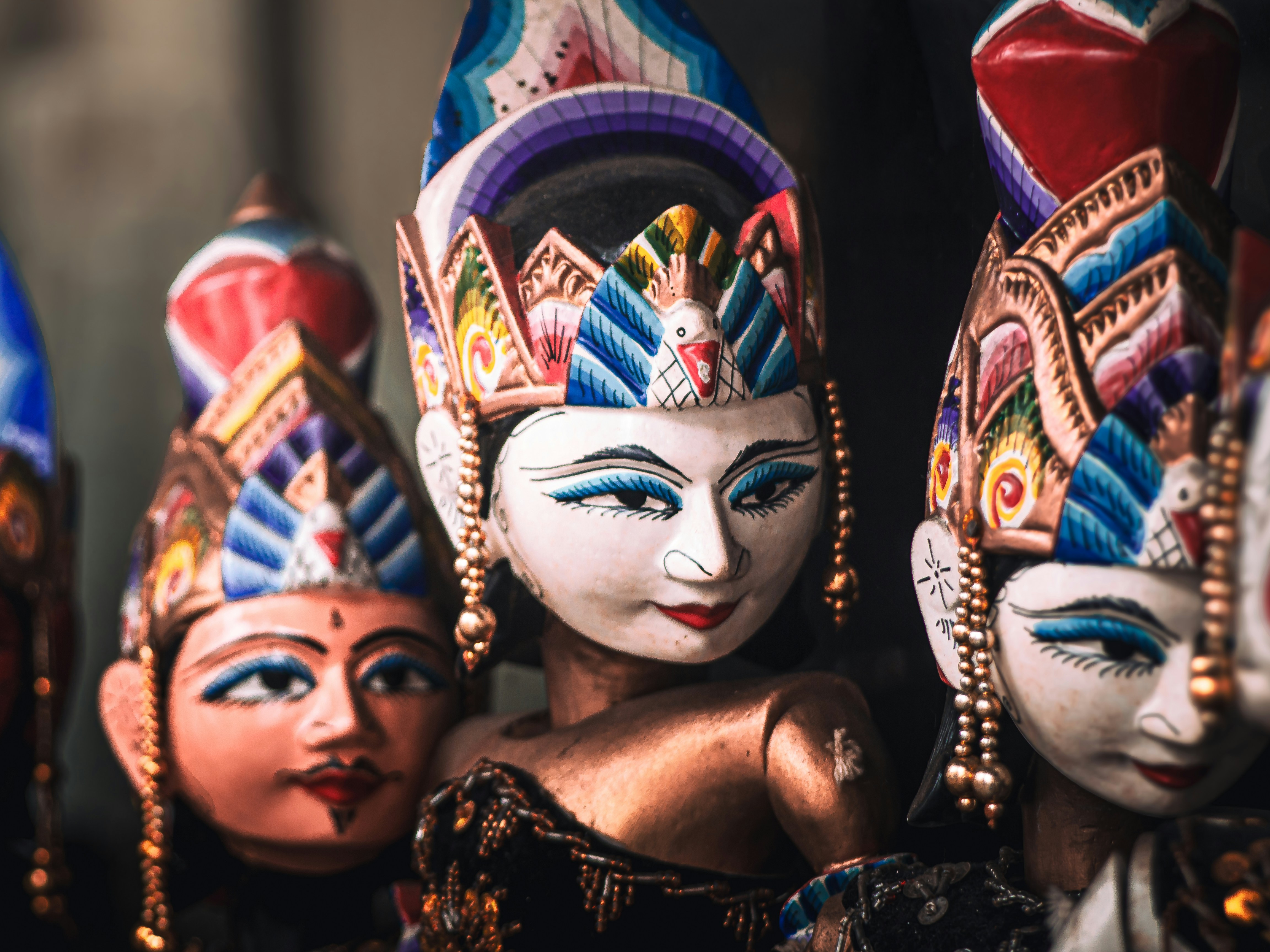 Colorful Carved Faces: A Trio of Festival Masks with Expressive Eyes